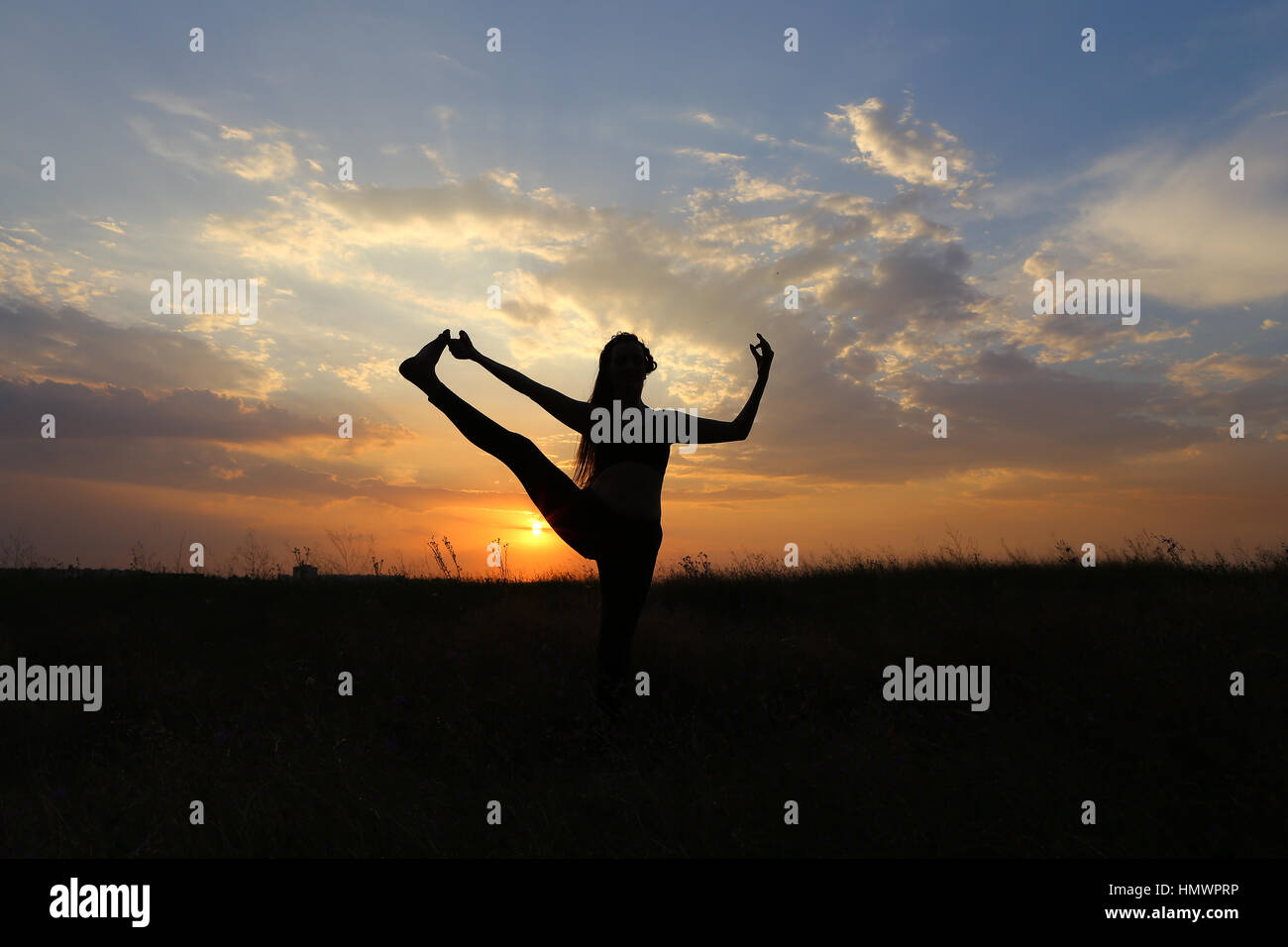 Female with beautiful figure takes yoga postures, gymnastics and ballet ...