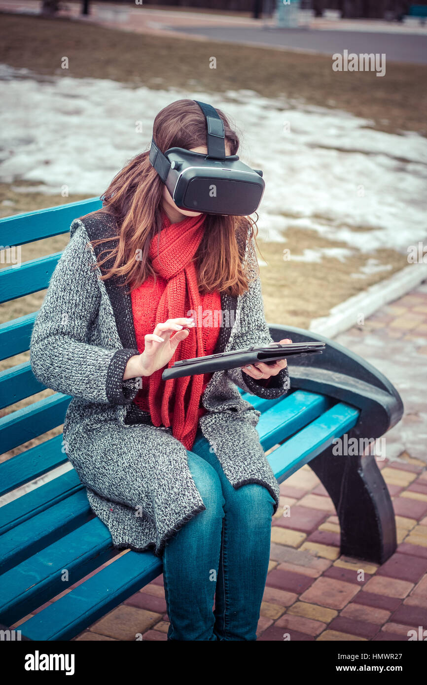 beautiful young girl with virtual reality VR headset and tablet on the ...