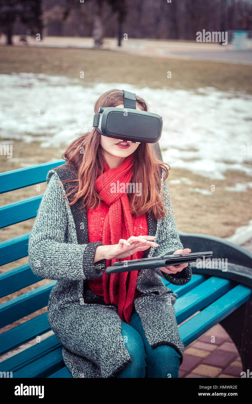 beautiful young girl with virtual reality VR headset and tablet on the ...