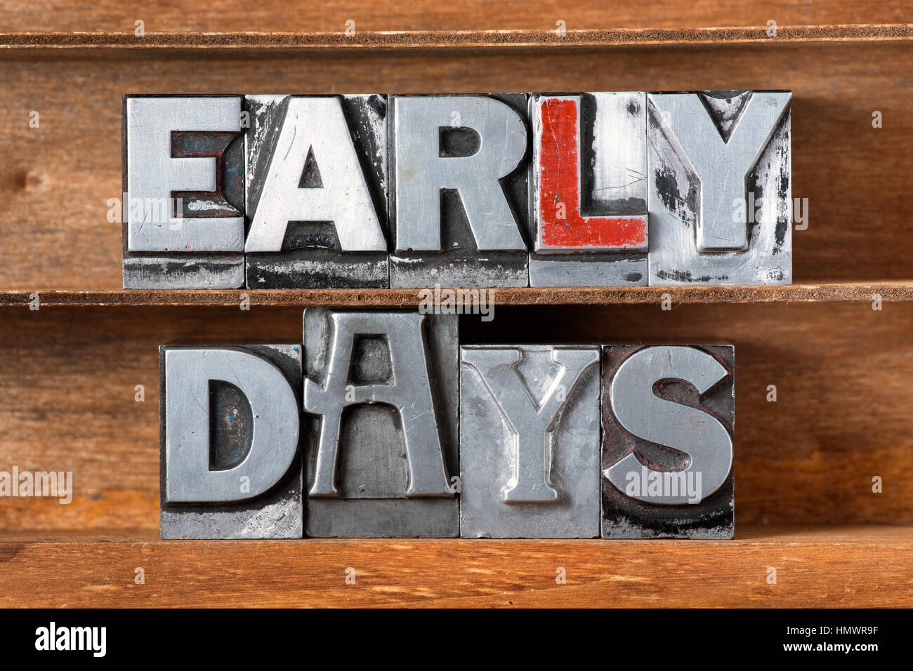 early days phrase made from metallic letterpress type on wooden tray ...