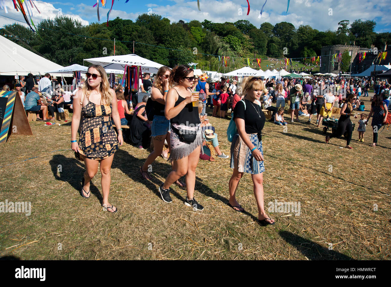 Four young trendy girls walk through the crowds at the Port Eliot ...