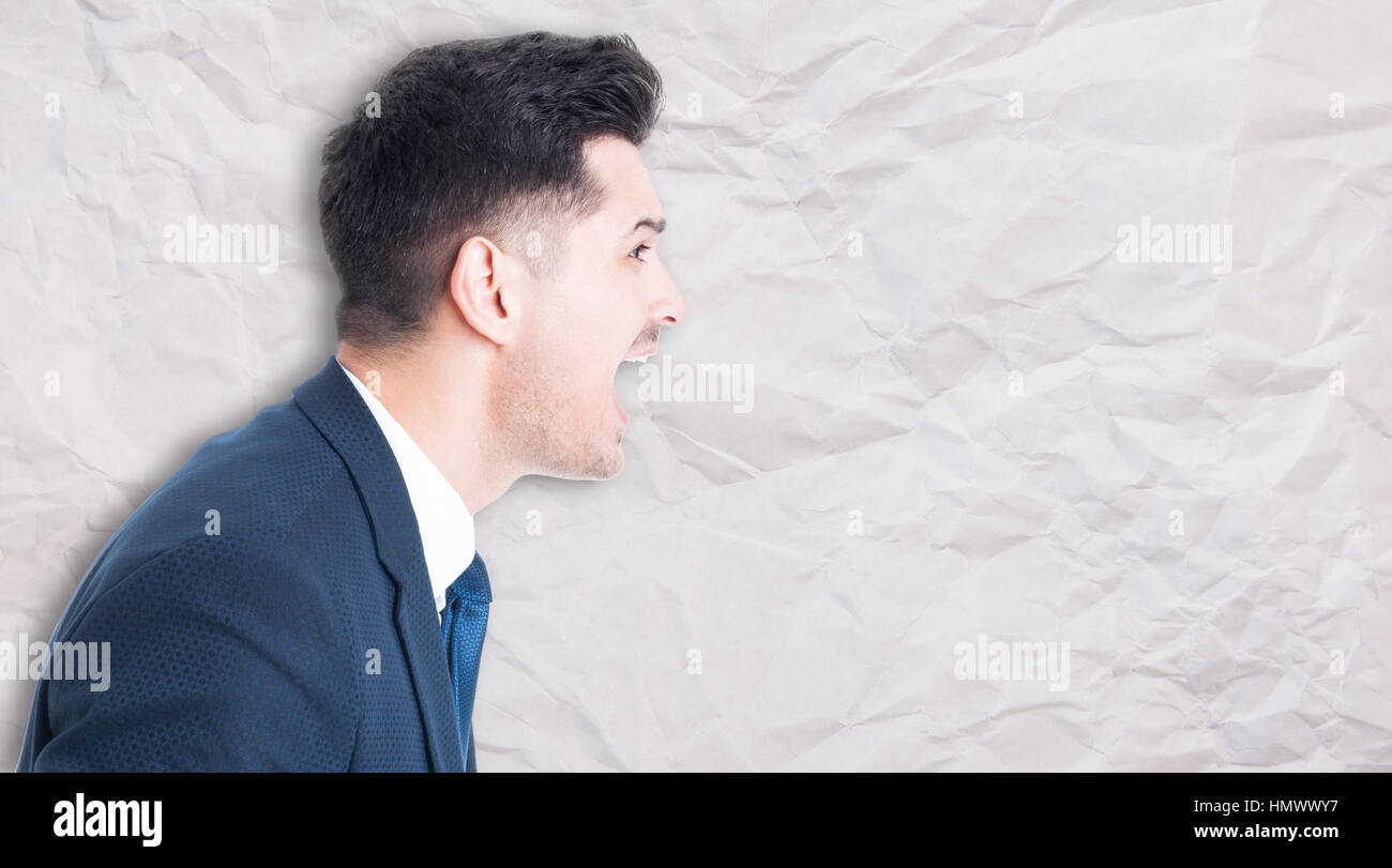 Side portrait of angry manager screaming out loud at somebody on ...