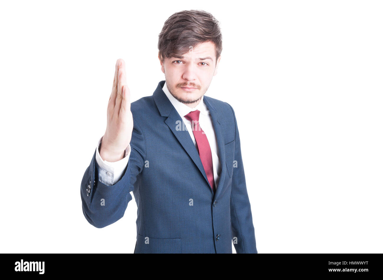 Young man wearing suit standing with one hand up like a constraint ...