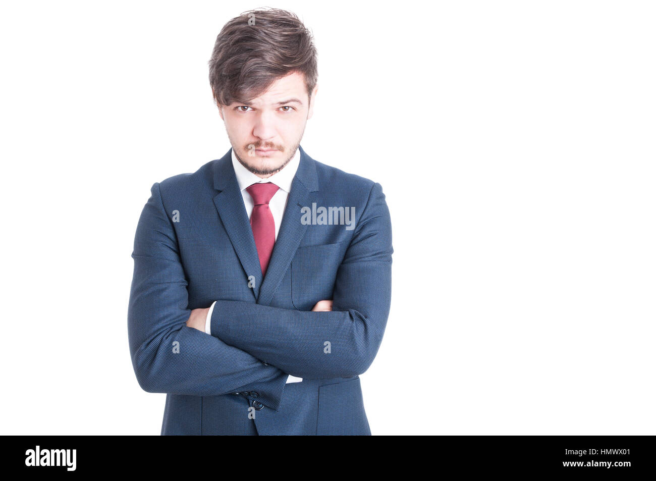 Young man wearing suit posing with arms crossed and head bowed looking ...
