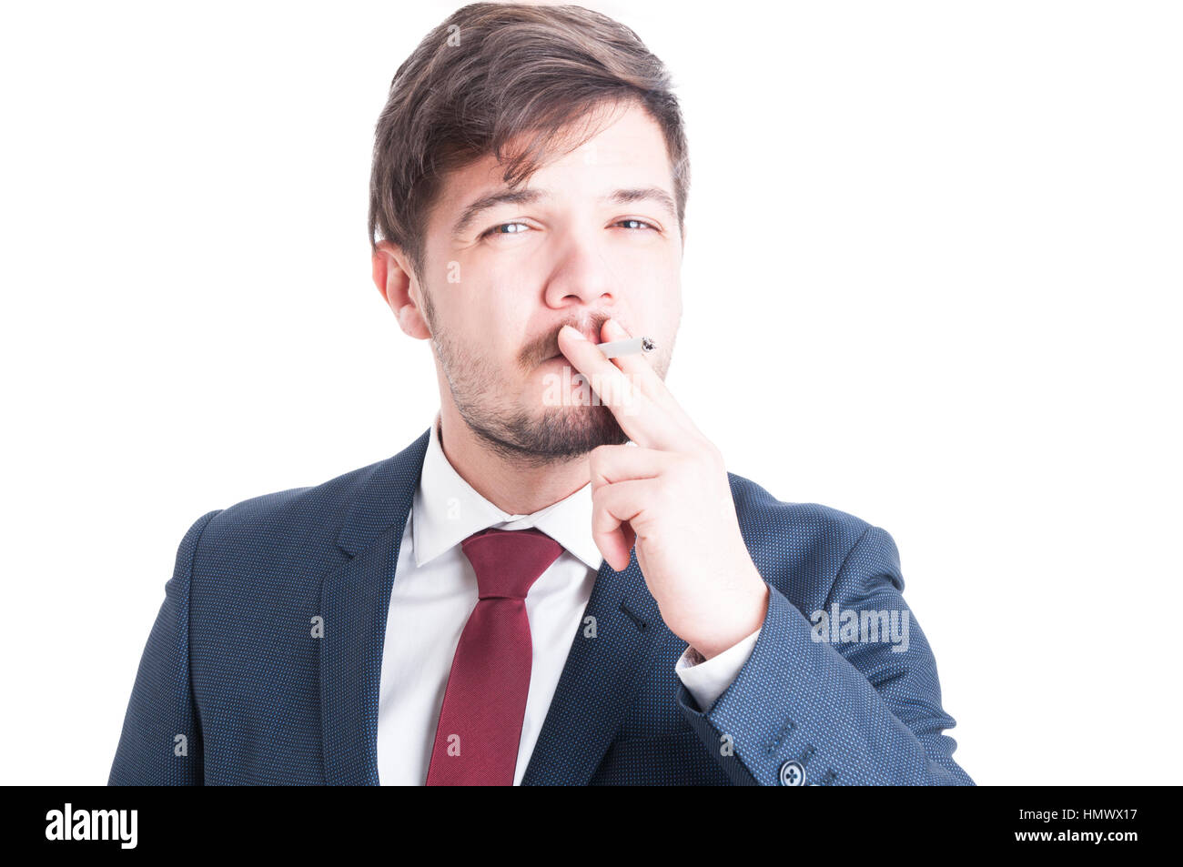 Man wearing suit enjoying smoking a cigarette isolated on white ...