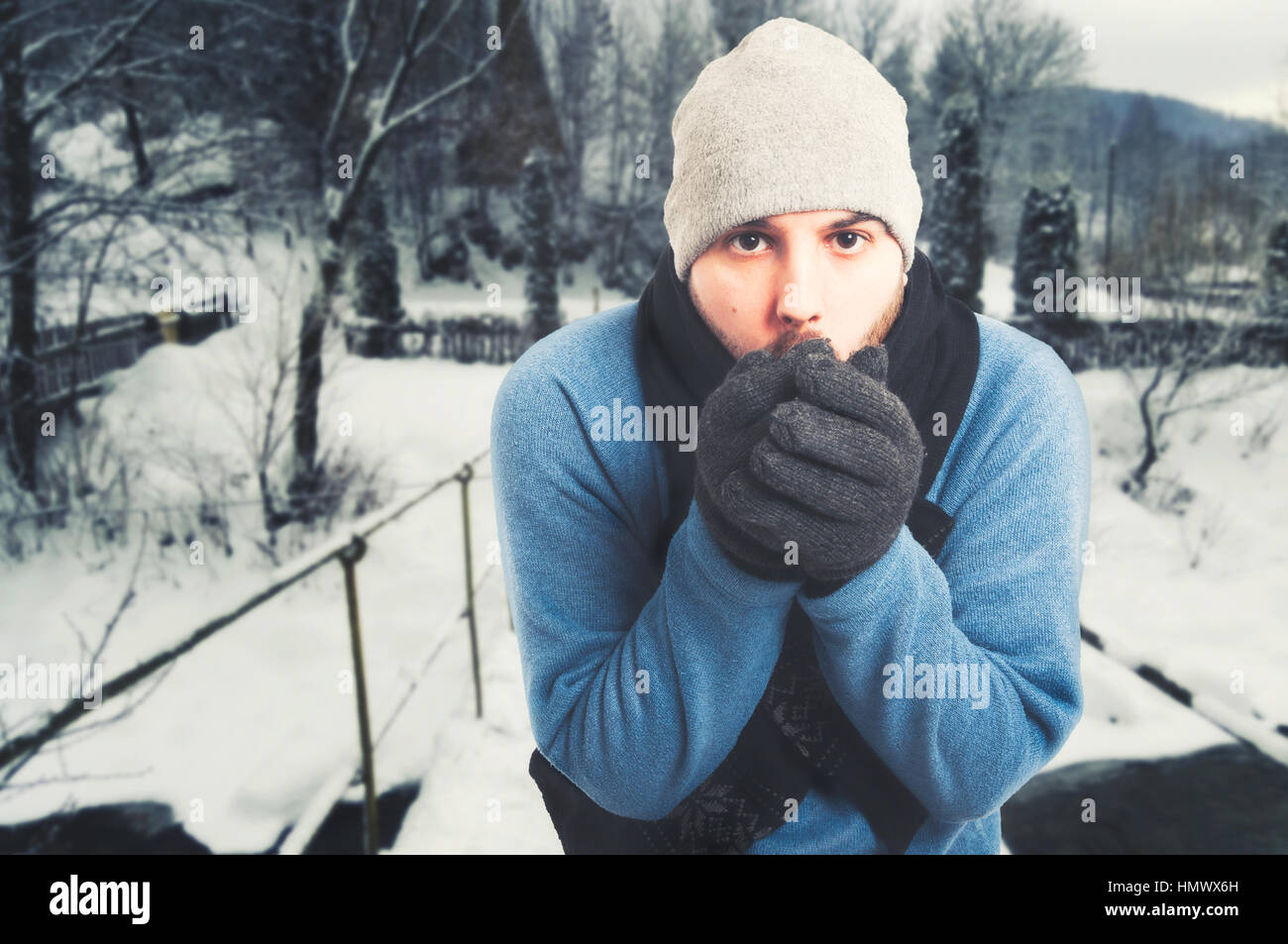 Handsome man sitting outside in winter season and freezing with ...