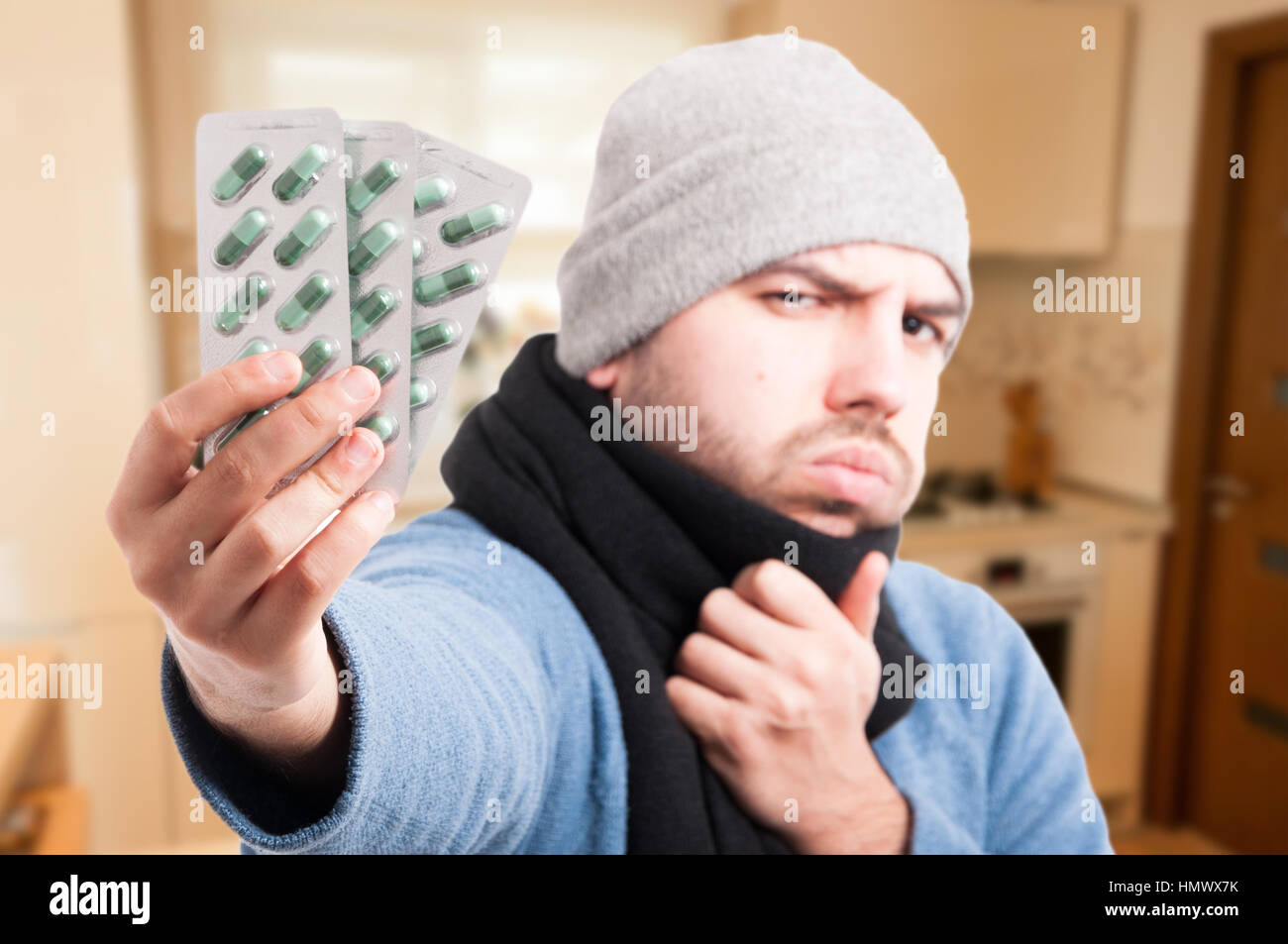 Sick man with fever holding tablet strips or antibiotics in his hand ...