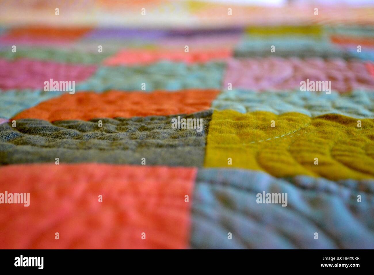 Handmade patchwork quilt in close up low angle with intricate stitching ...