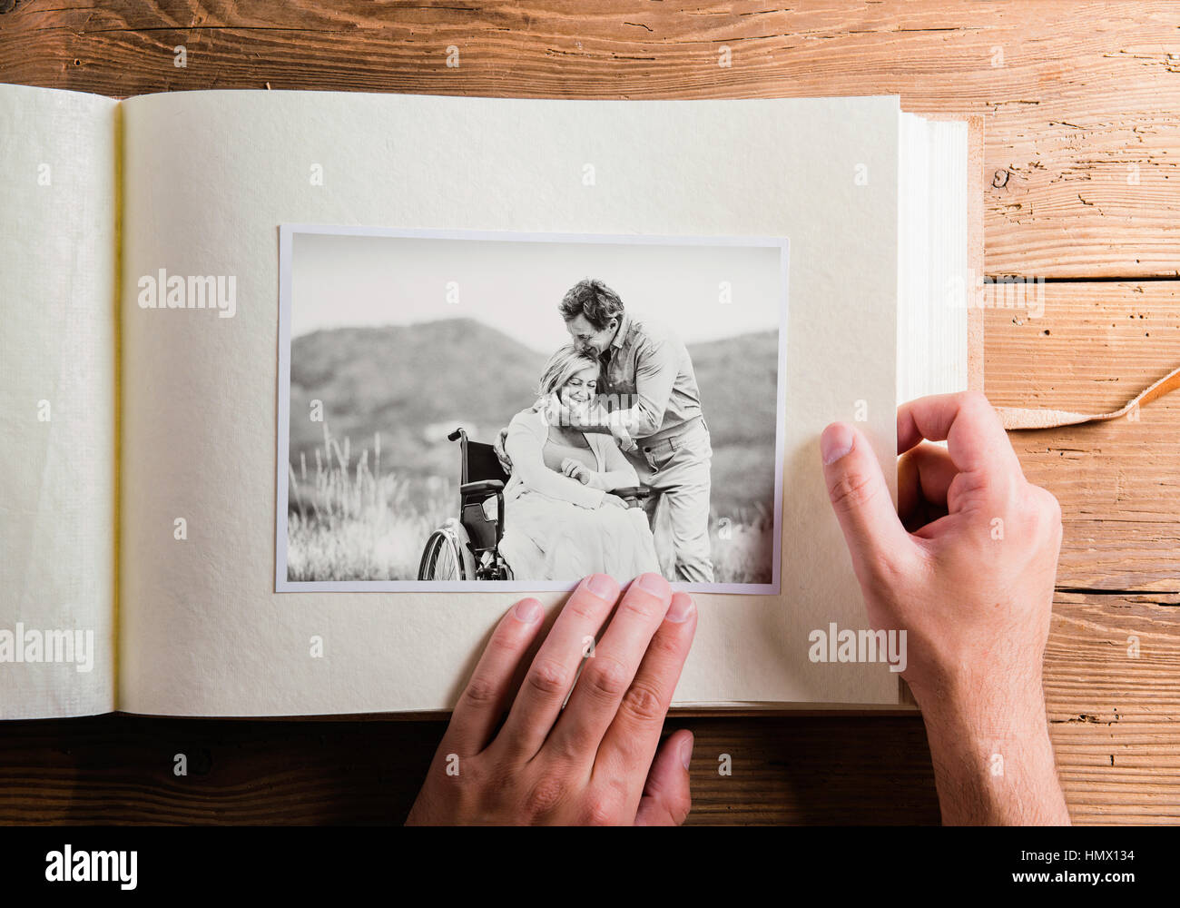 Hands holding photo album with picture of senior couple. Studio Stock ...