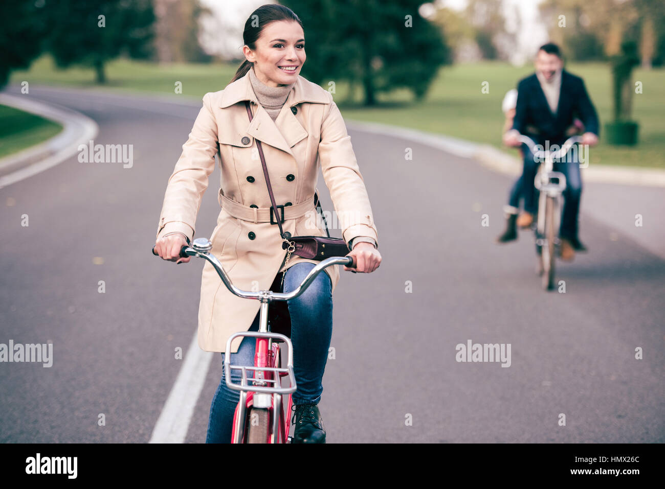 Beautiful smiling woman riding bicycle Stock Photo - Alamy