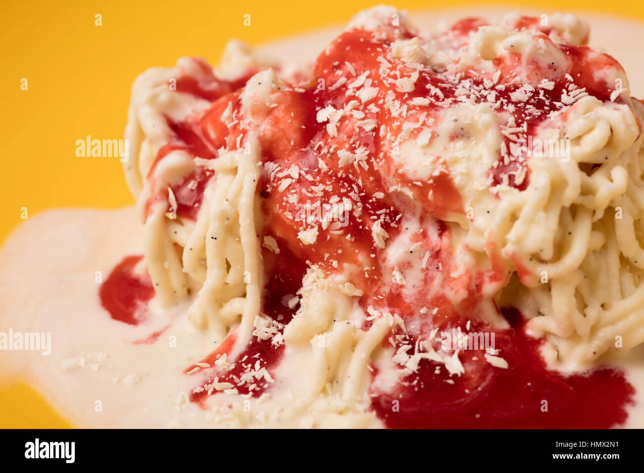 Homemade spaghetti ice cream with red strawberry sauce and white ...