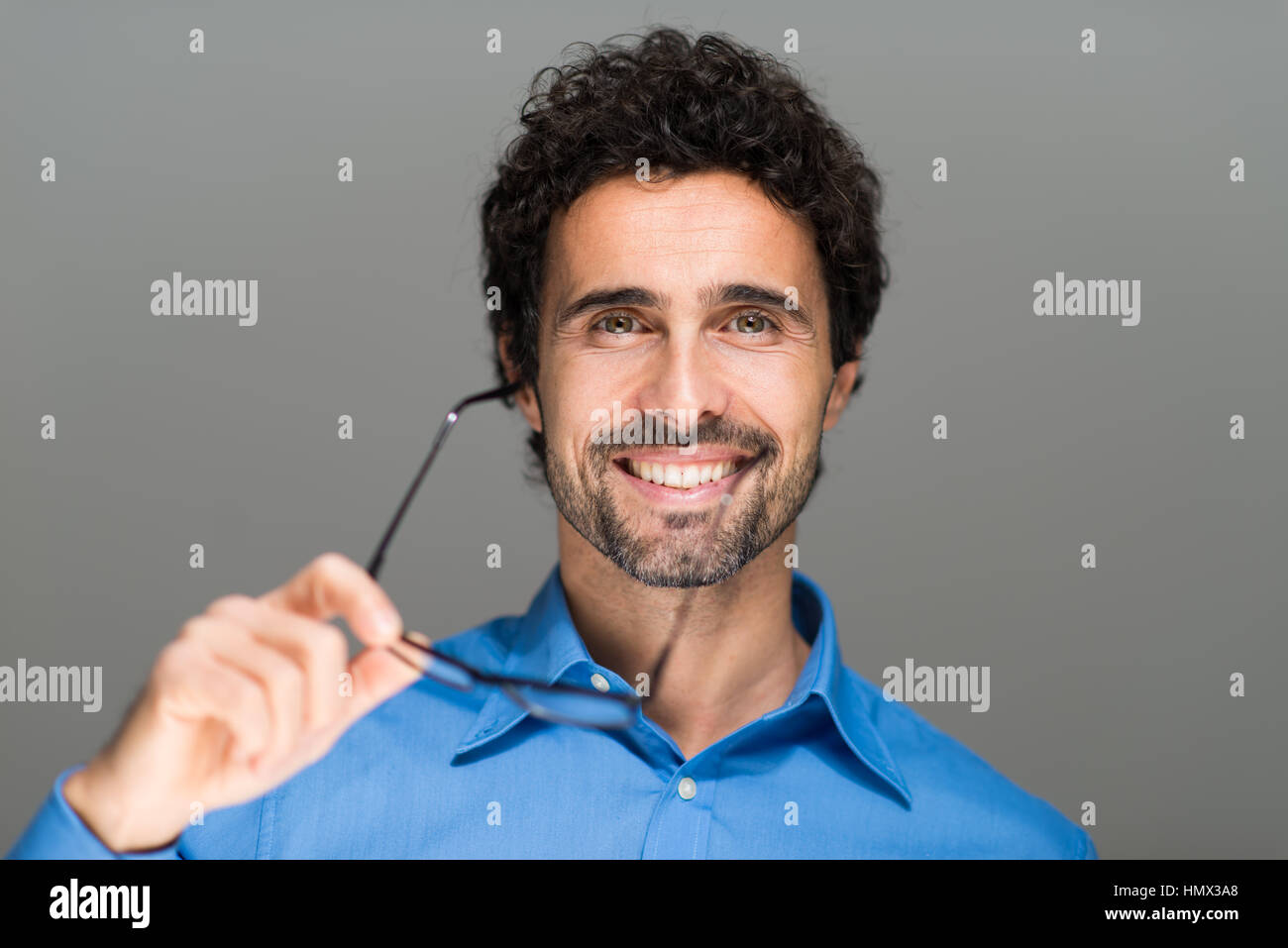 Portrait of a handsome man holding eyeglasses Stock Photo - Alamy