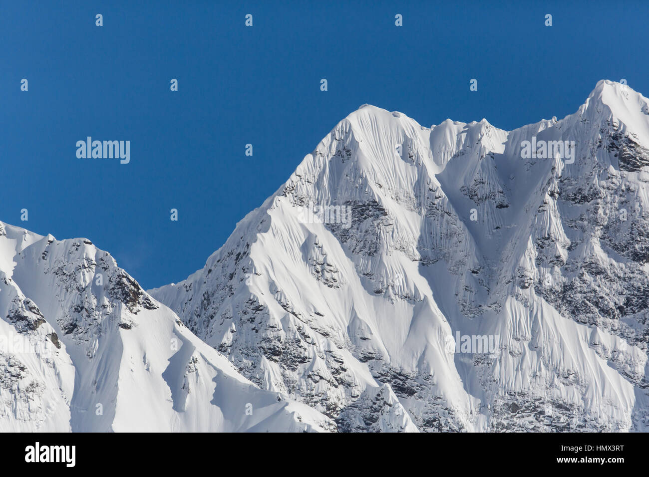 Mountain peaks and crests with snow in winter and blue sky Stock Photo ...