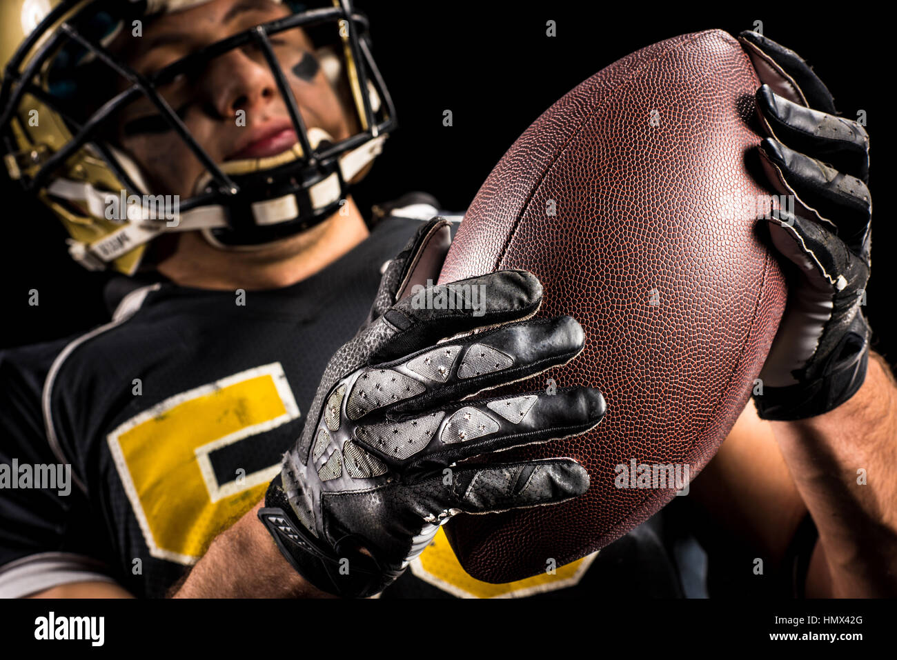 American football player holding ball Stock Photo - Alamy