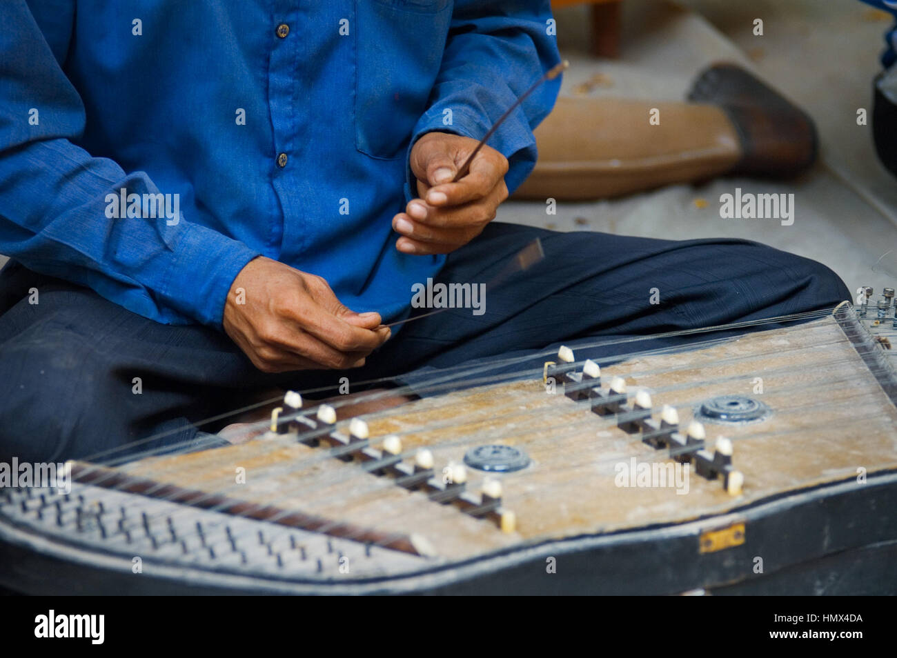 Close-up hands of landmine victim playing a Thai Khim musical ...