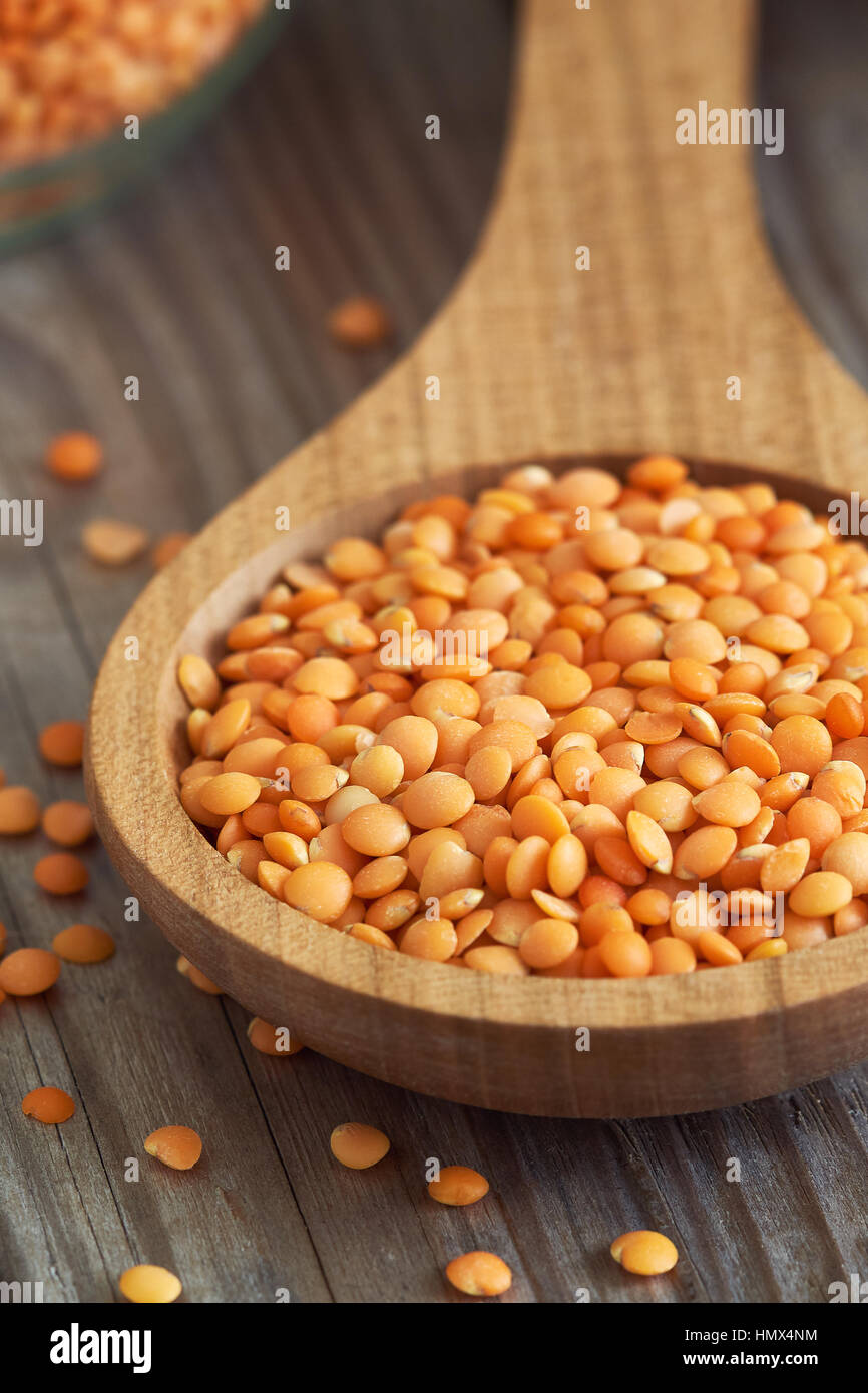 Raw uncooked red lentils in wooden spoon on rustic background Stock ...