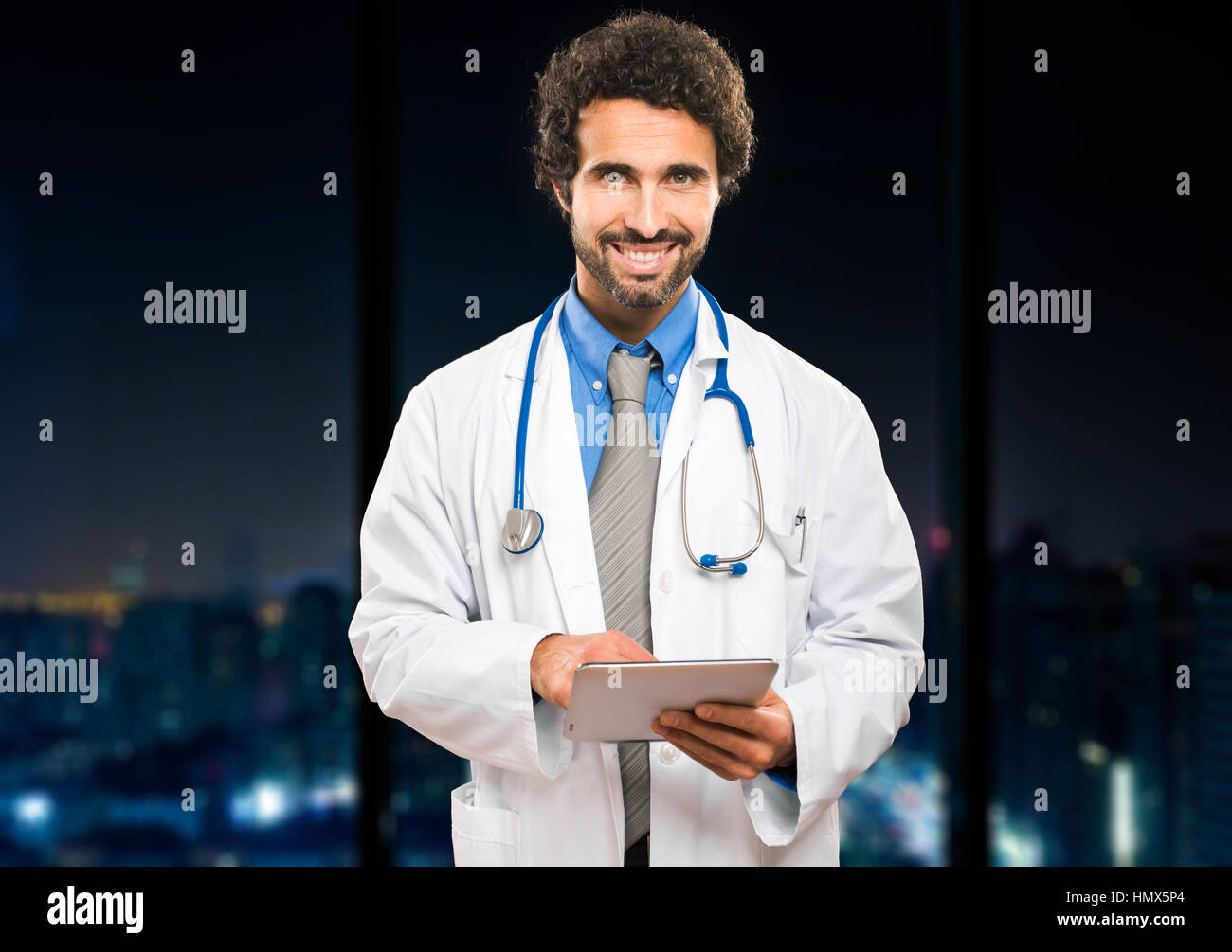 Doctor checking his tablet in his studio Stock Photo - Alamy