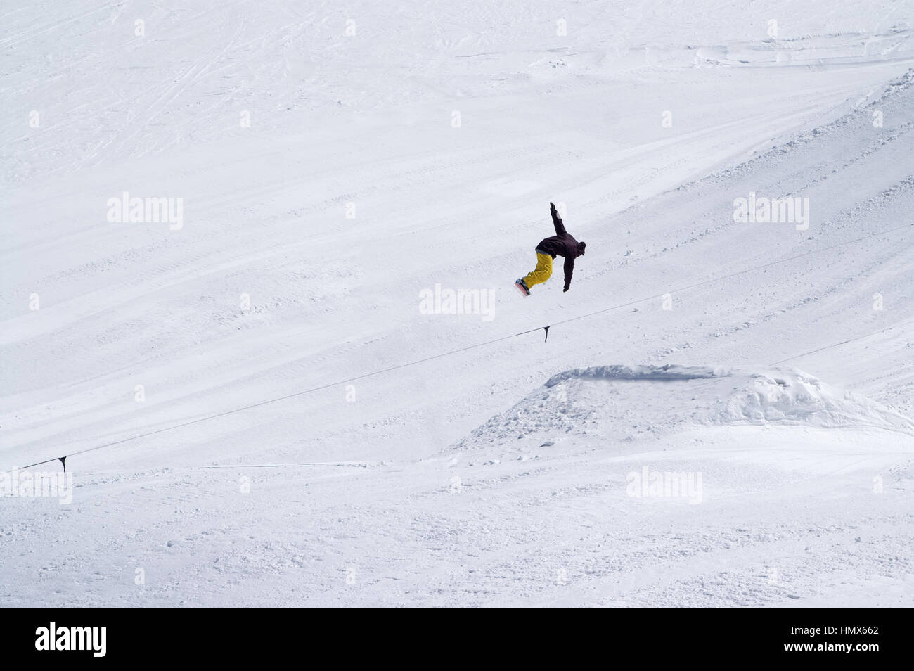 Snowboarder jumping in snow park at ski resort on sun winter day ...