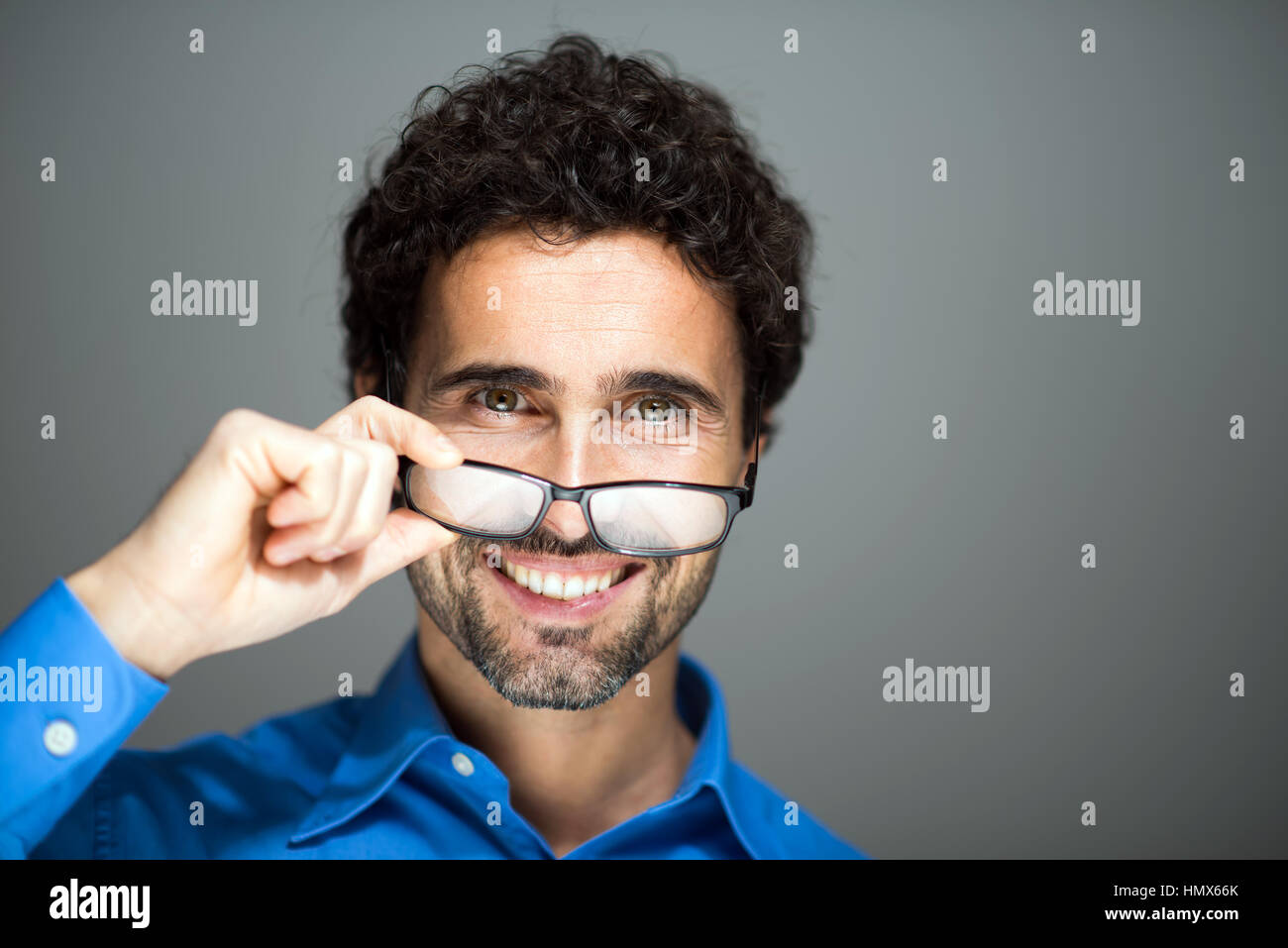 Close-up portrait of attractive young man holding glasses Stock Photo ...