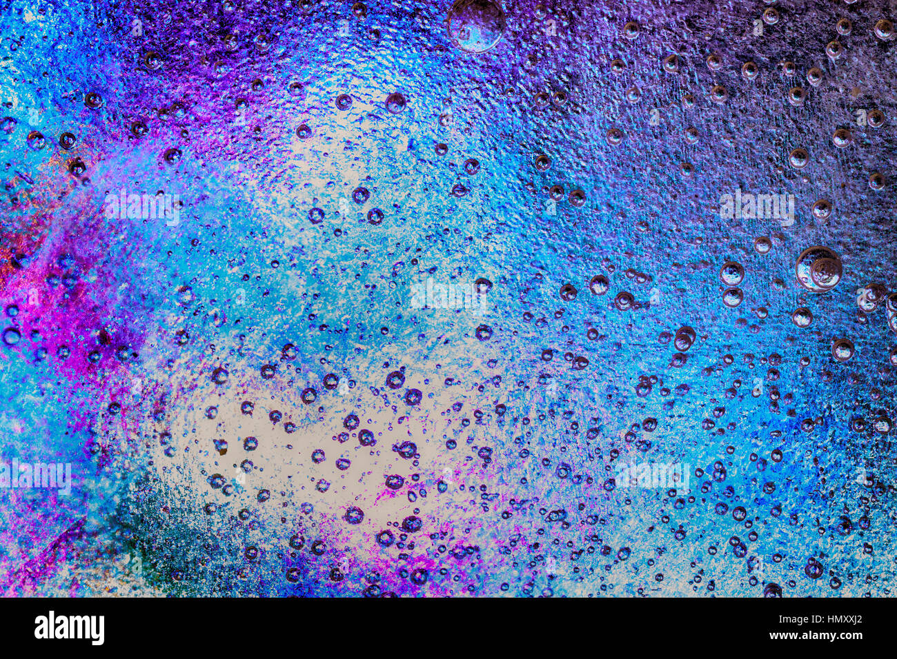 Frozen ice crystals with beautiful pink, blue and purple colour below ...