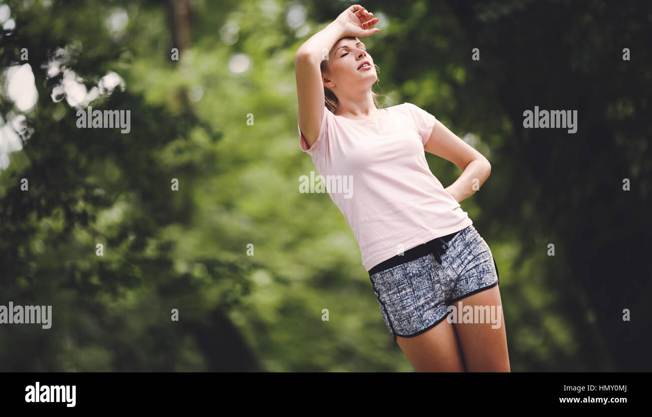 Exhausted female jogger grasping for air in park Stock Photo - Alamy