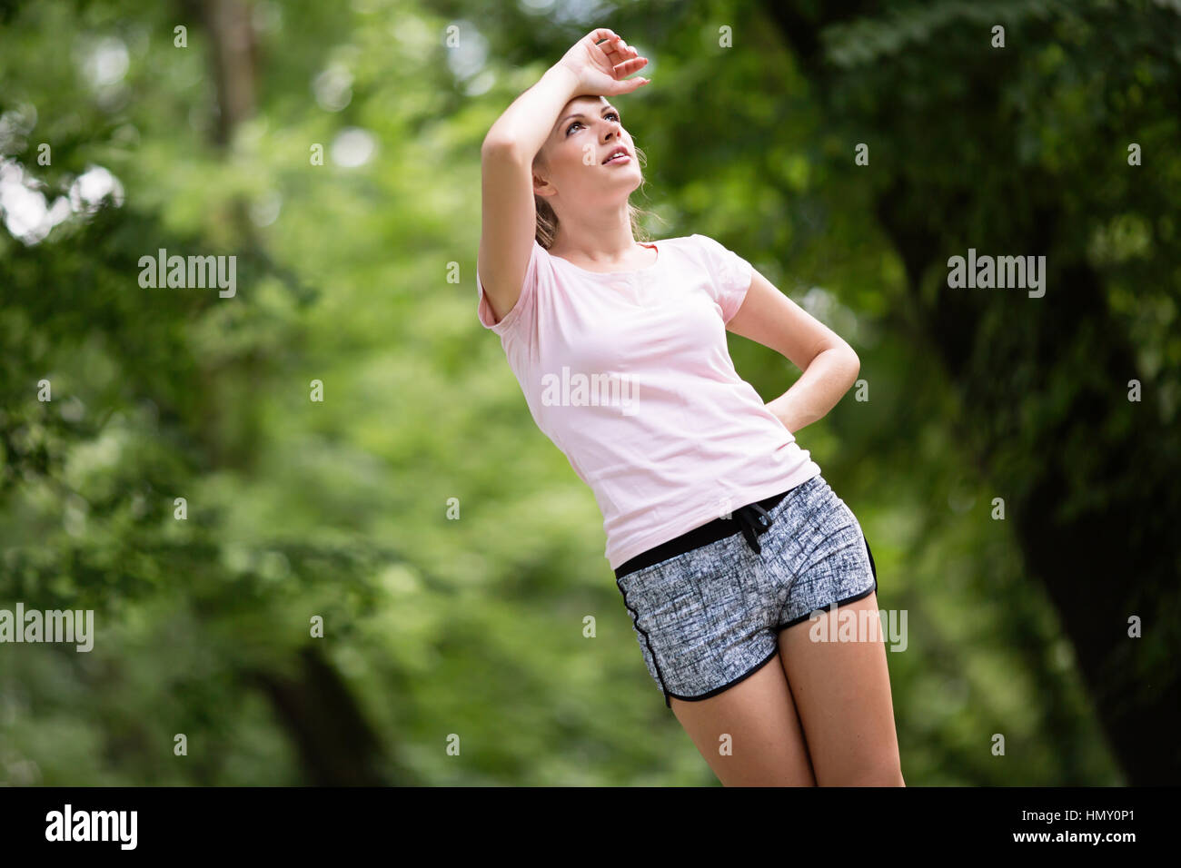 Exhausted female jogger grasping for air in park Stock Photo - Alamy