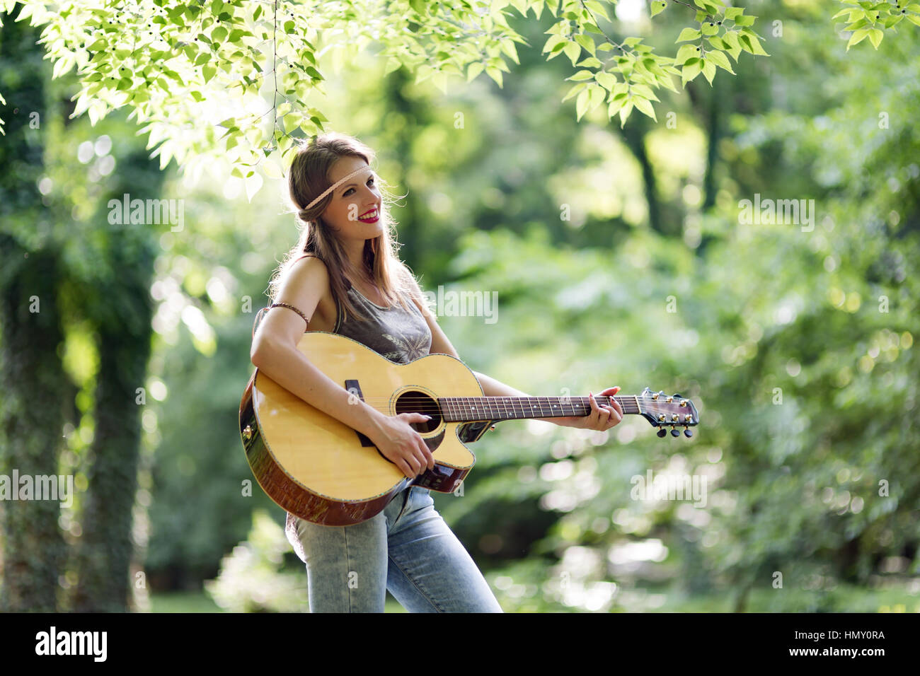 Beautiful woman playing acoustic guitar in nature Stock Photo - Alamy