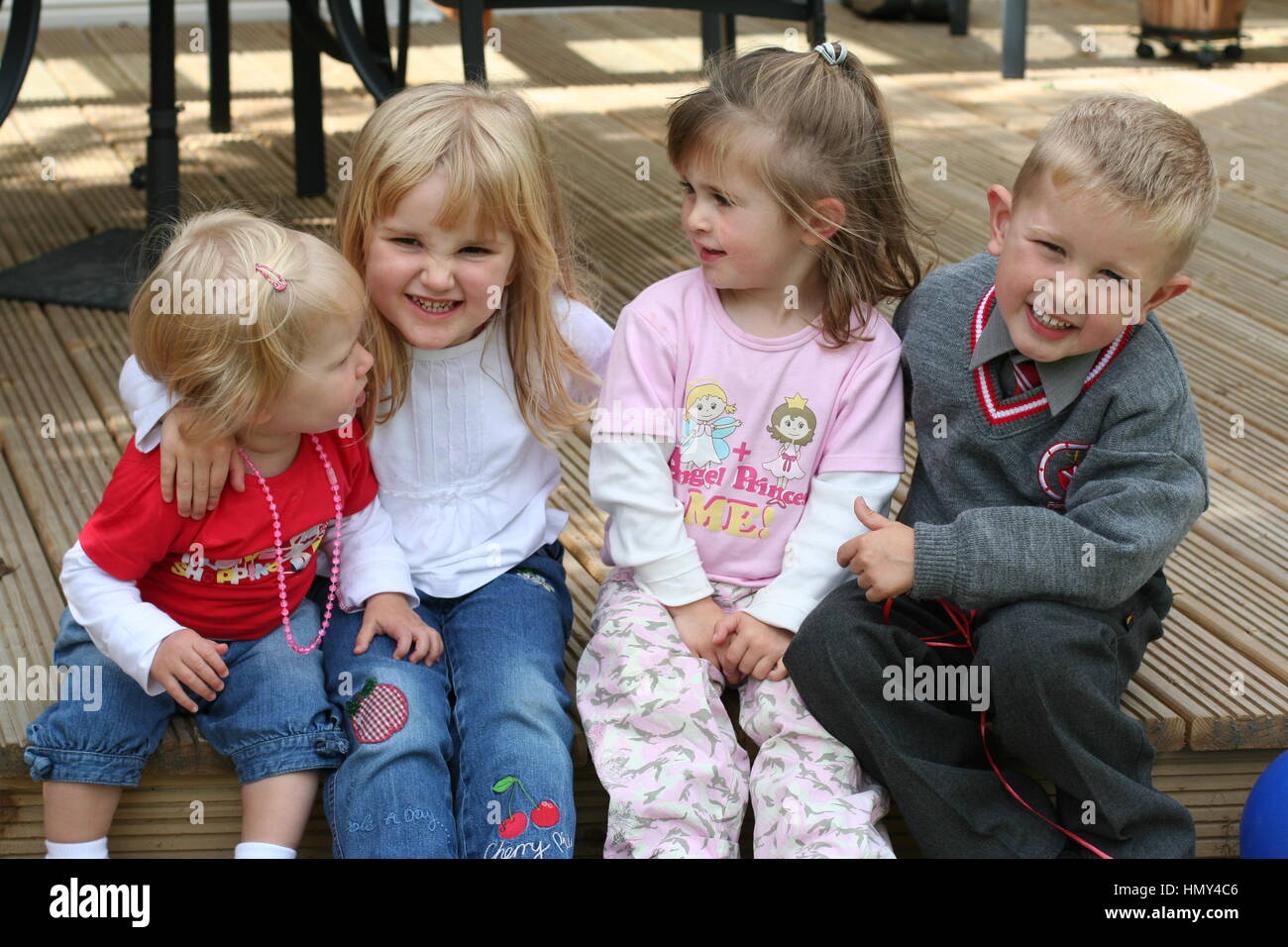 Group of children sitting together, hanging out, playing in the garden ...