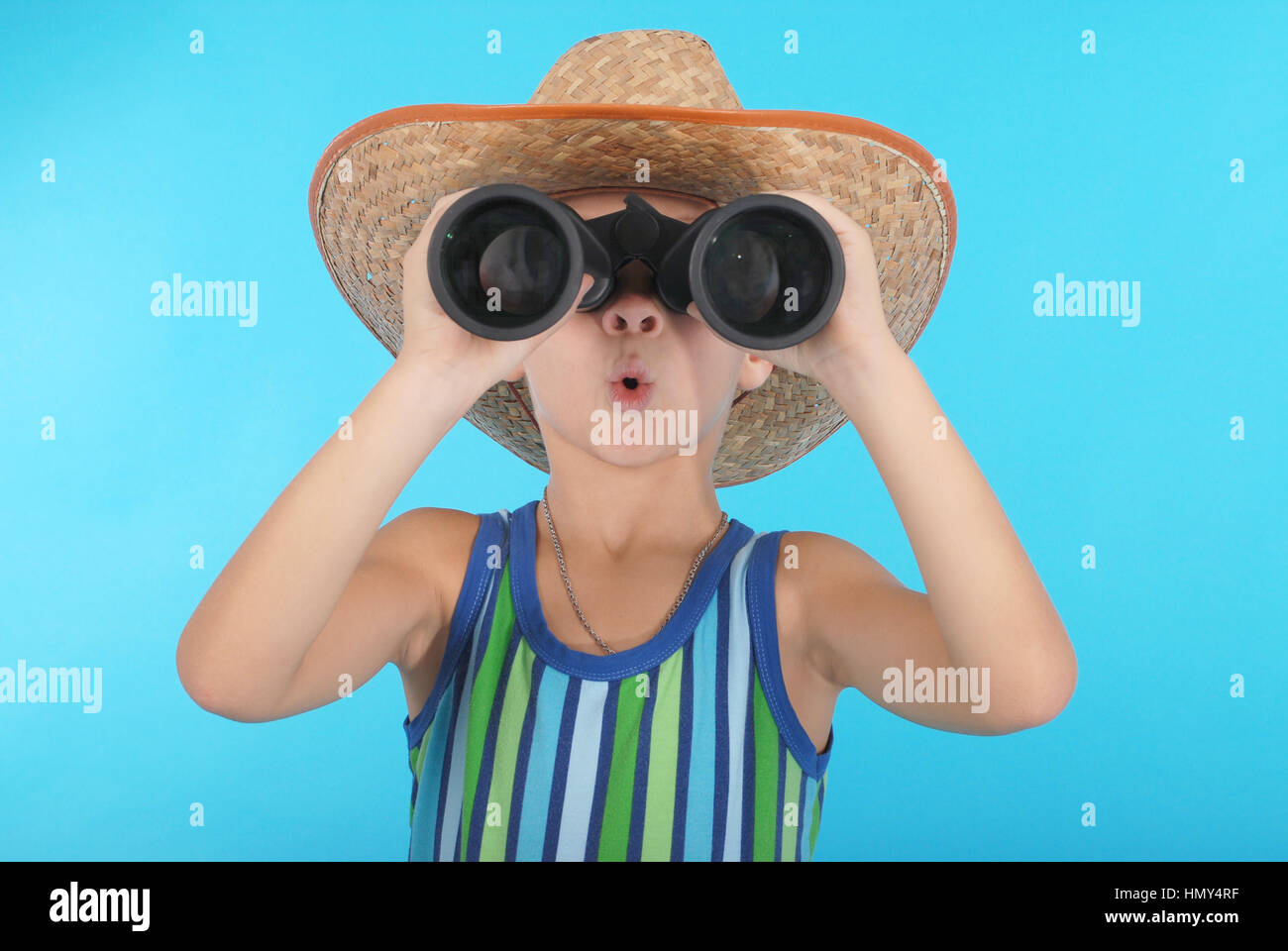 Curious boy in cowboy hat looking through binoculars. Photo close-up on ...