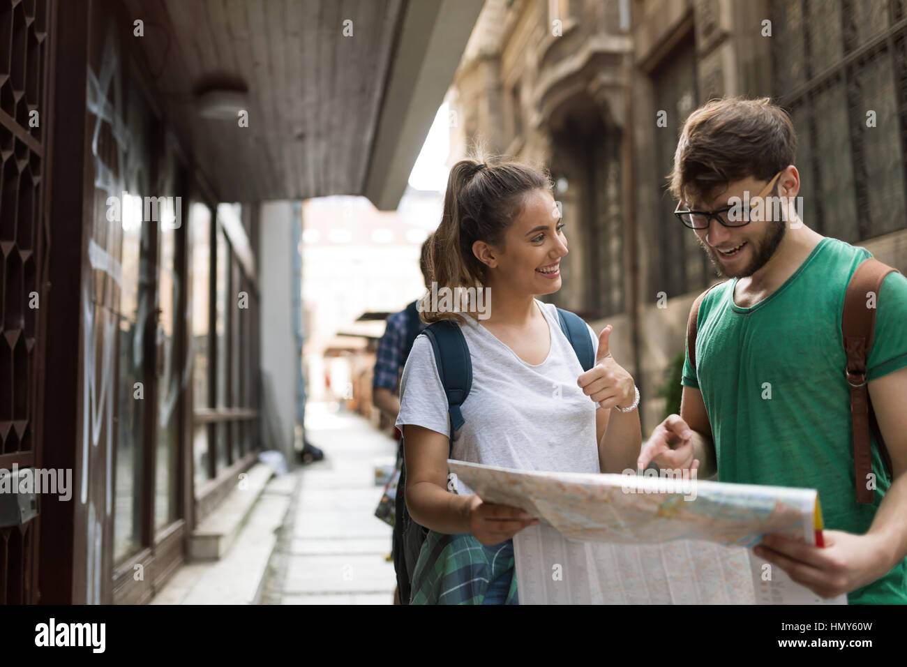 Young happy tourists holding map sightseeing in city Stock Photo - Alamy