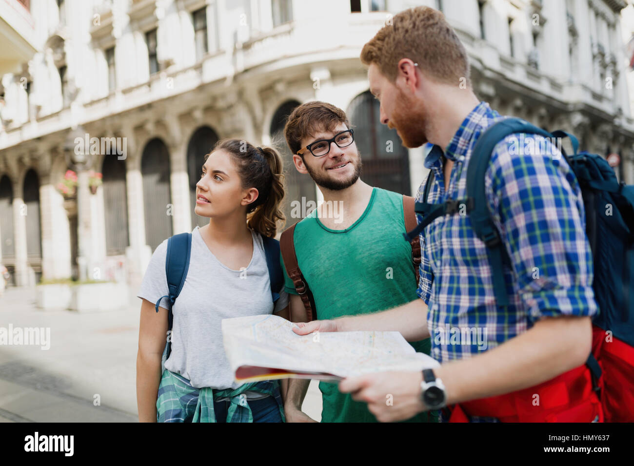 Young happy tourists holding map sightseeing in city Stock Photo - Alamy