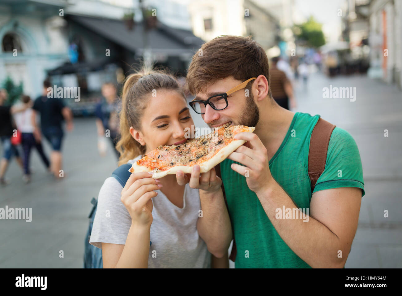 Positive happy students eating pizza on street Stock Photo - Alamy