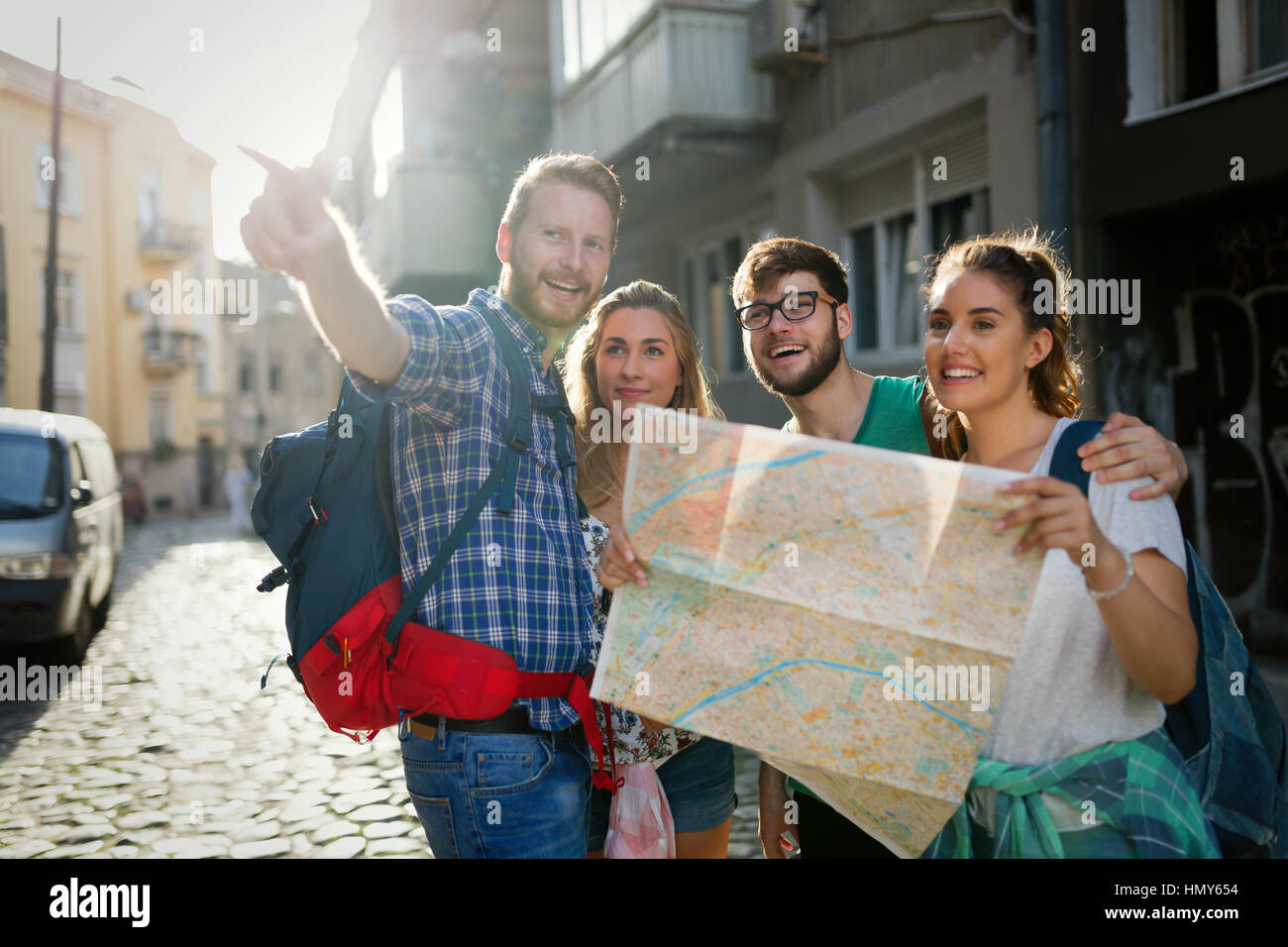 Young happy tourists holding map sightseeing in city Stock Photo - Alamy