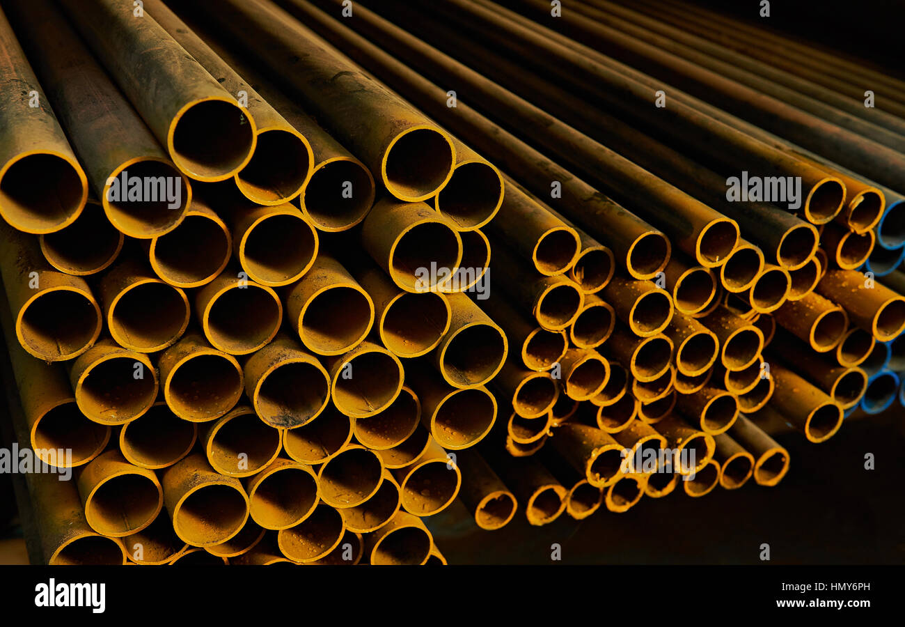 stack of colored iron round tubes in warehouse Stock Photo - Alamy
