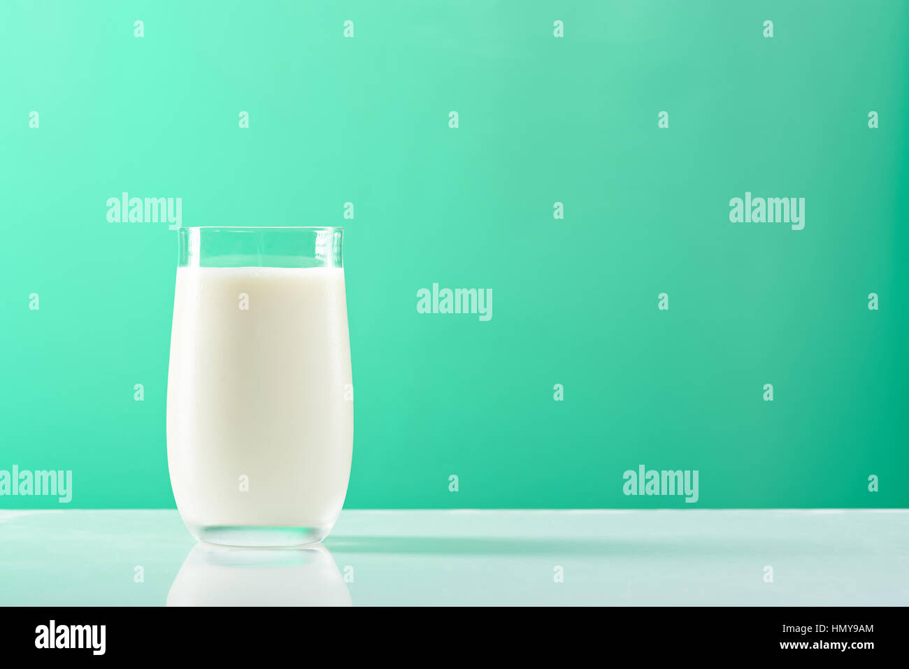 full milk glass on green background isolated Stock Photo - Alamy