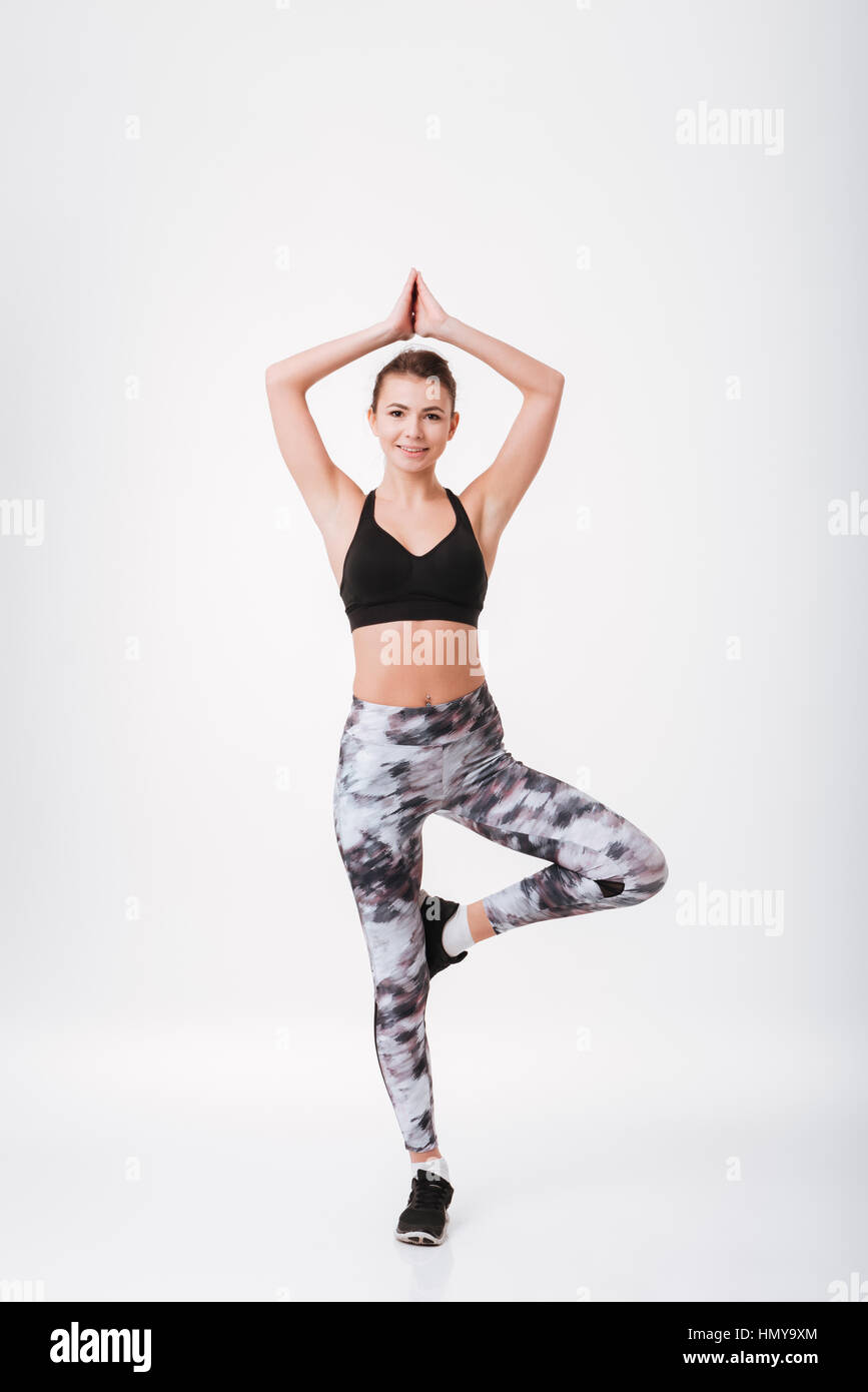 Picture of attractive young fitness lady standing isolated over white ...