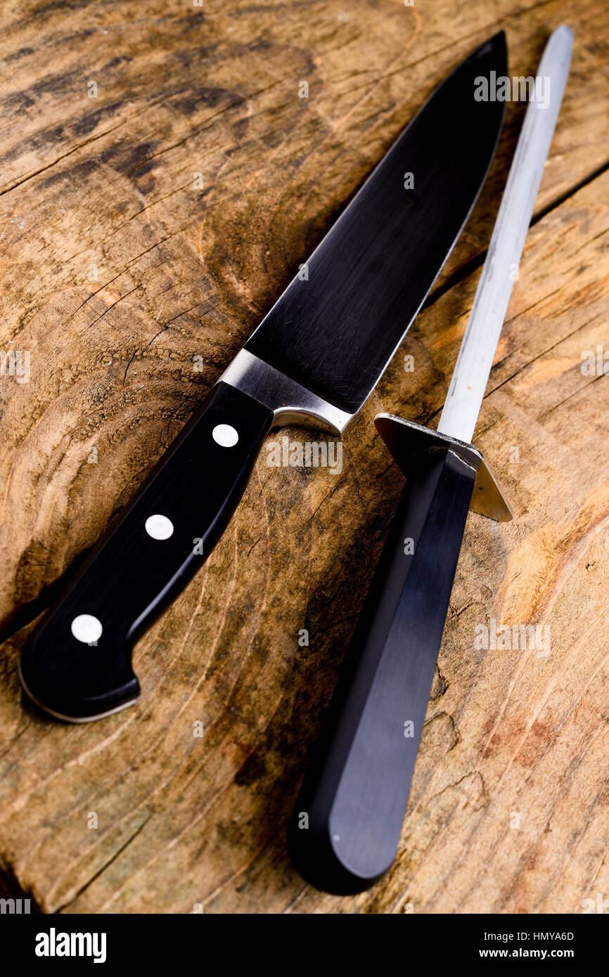 knife and sharpener on wooden table Stock Photo - Alamy