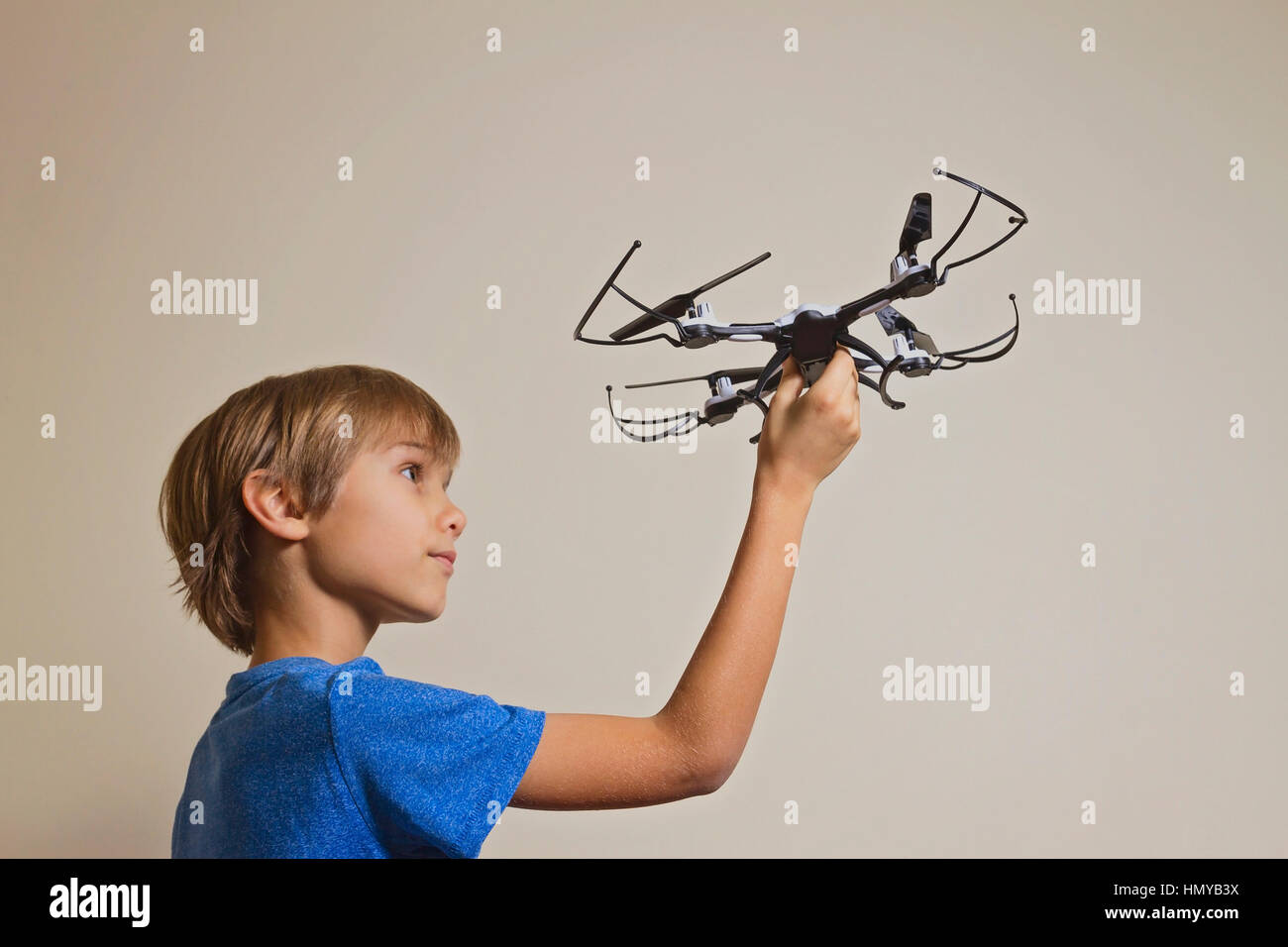 Little kid playing with drone. Boy holding quadcopter in his hand ...