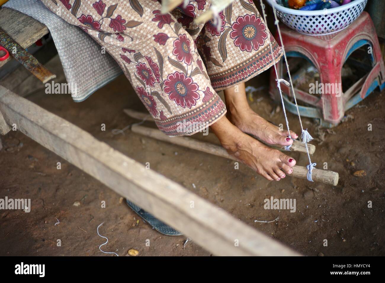 Woman woving Lao Silk using a traditional wooden machine in Ban Xang ...
