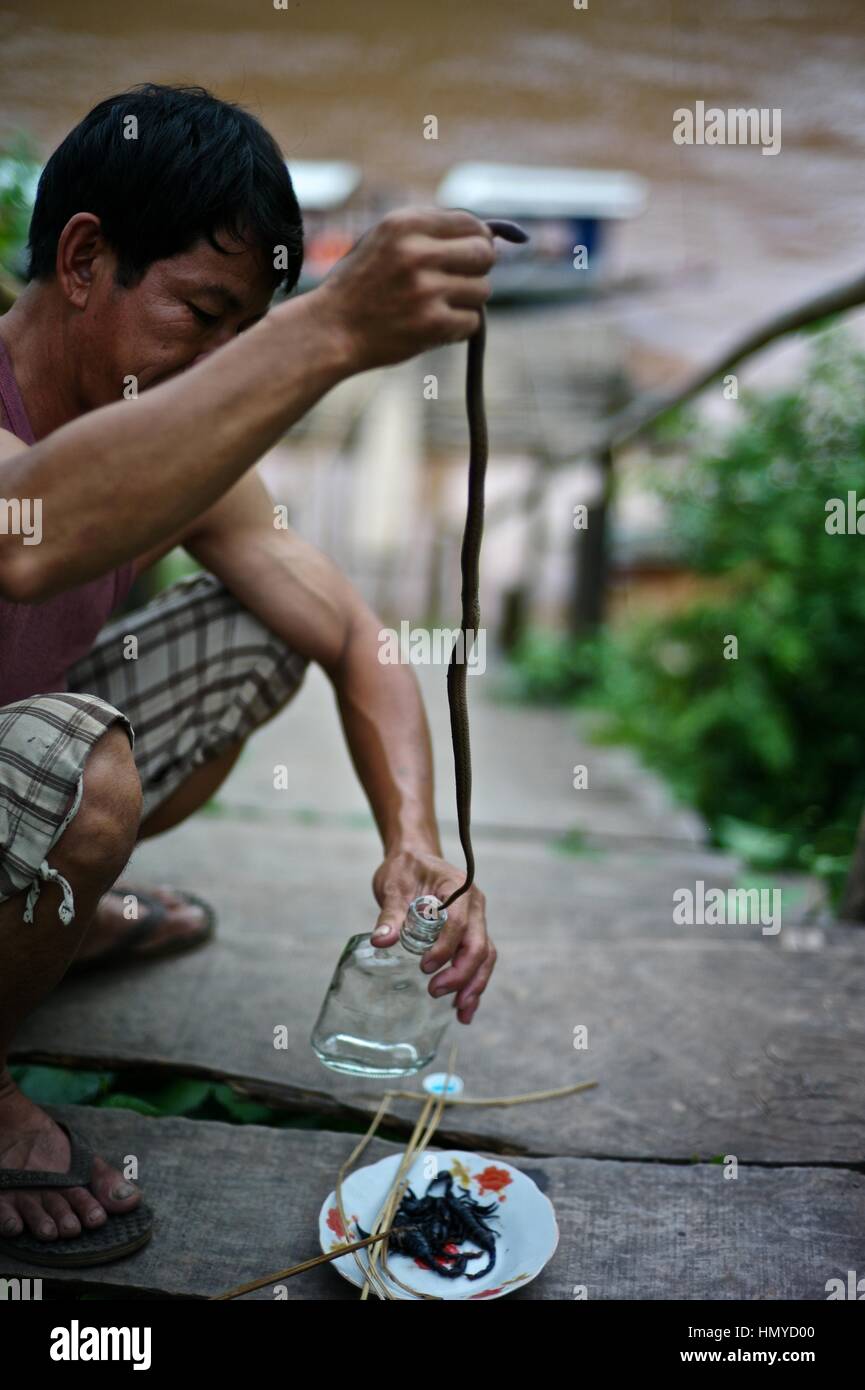 A man prepares Lao Lao whiskey in Whisky Village, known as Ban Xang Hai ...