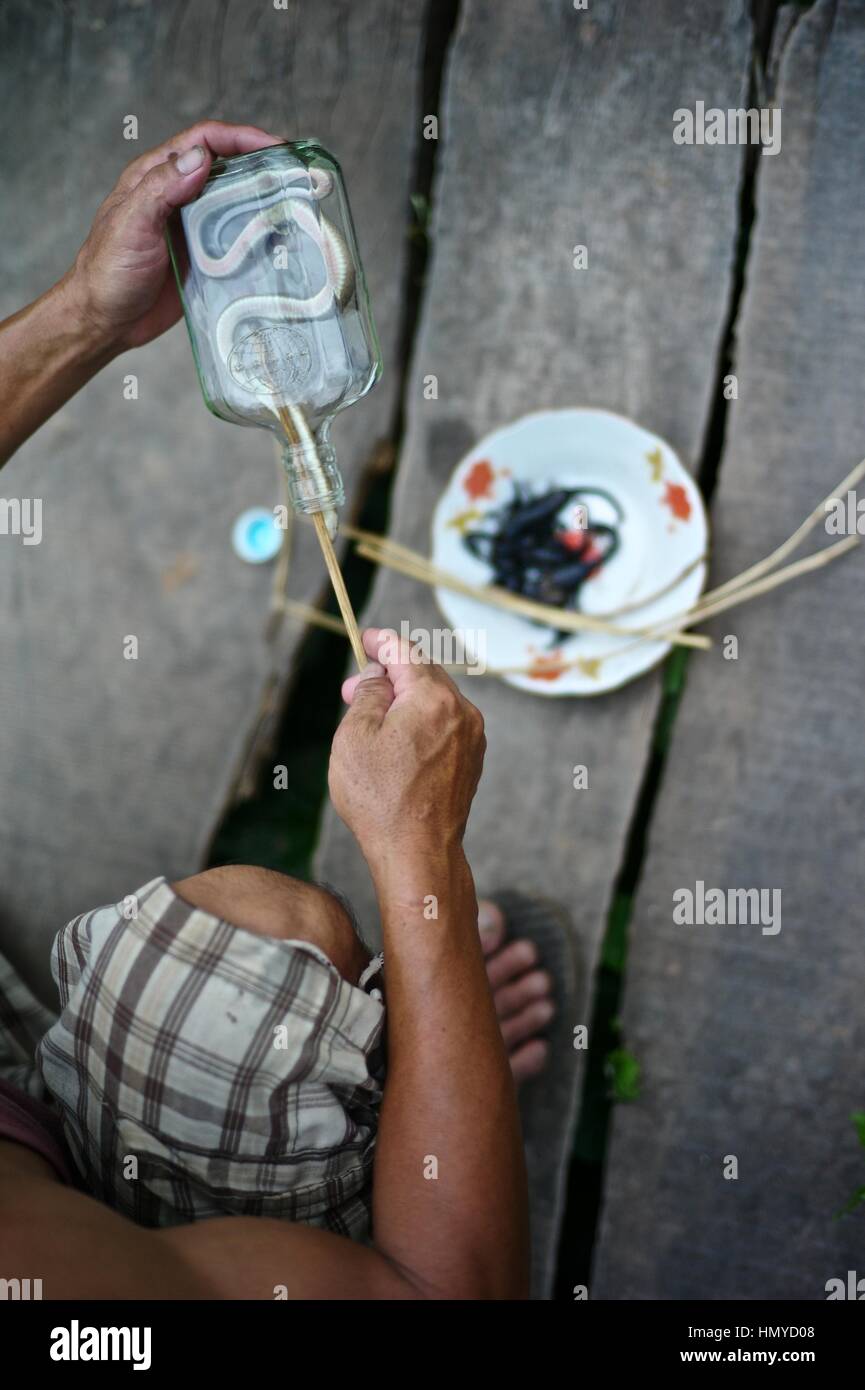 A man prepares Lao Lao whiskey in Whisky Village, known as Ban Xang Hai ...