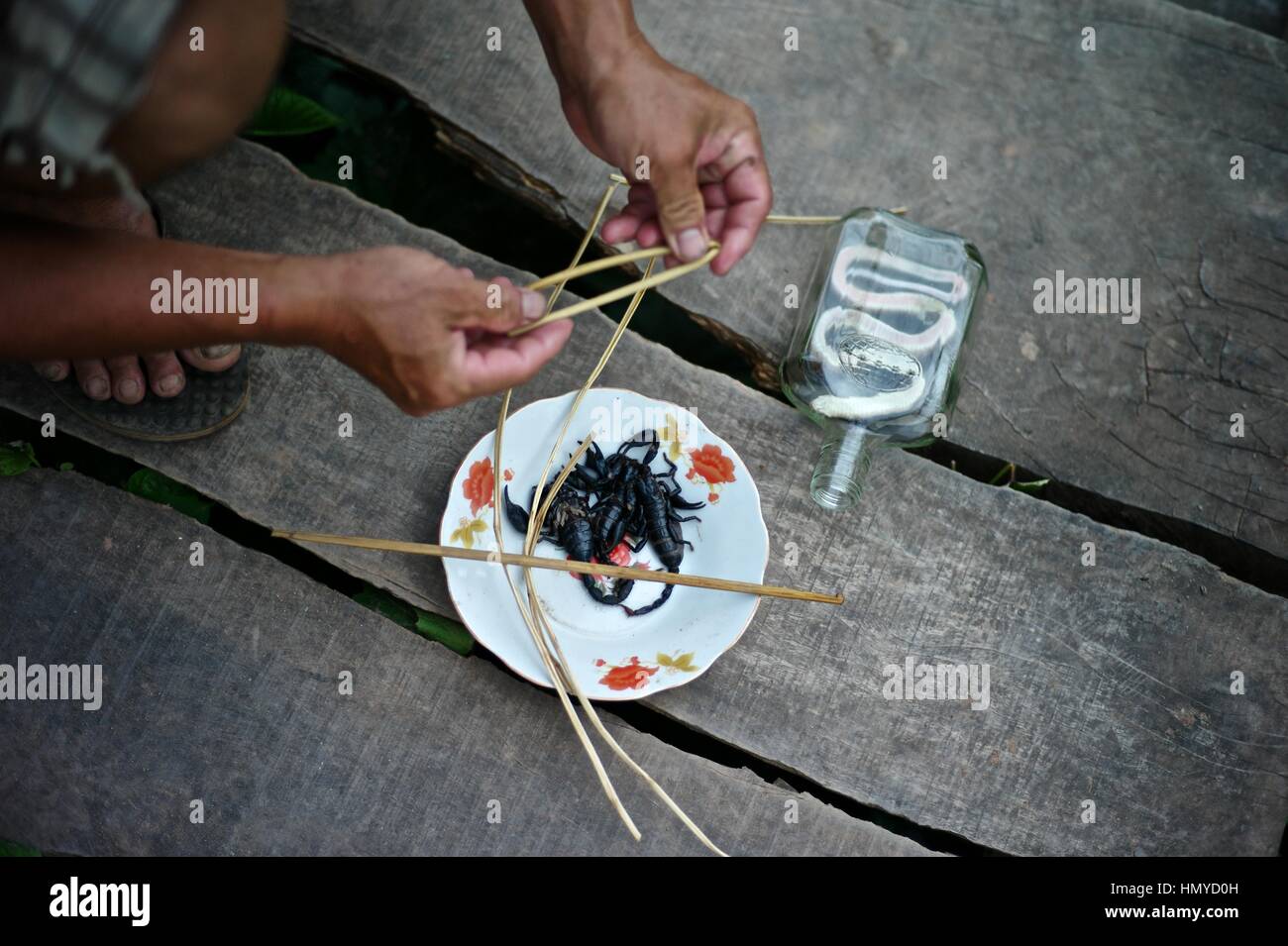 A man prepares Lao Lao whiskey in Whisky Village, known as Ban Xang Hai ...