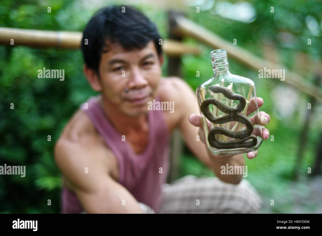 A man prepares Lao Lao whiskey in Whisky Village, known as Ban Xang Hai ...