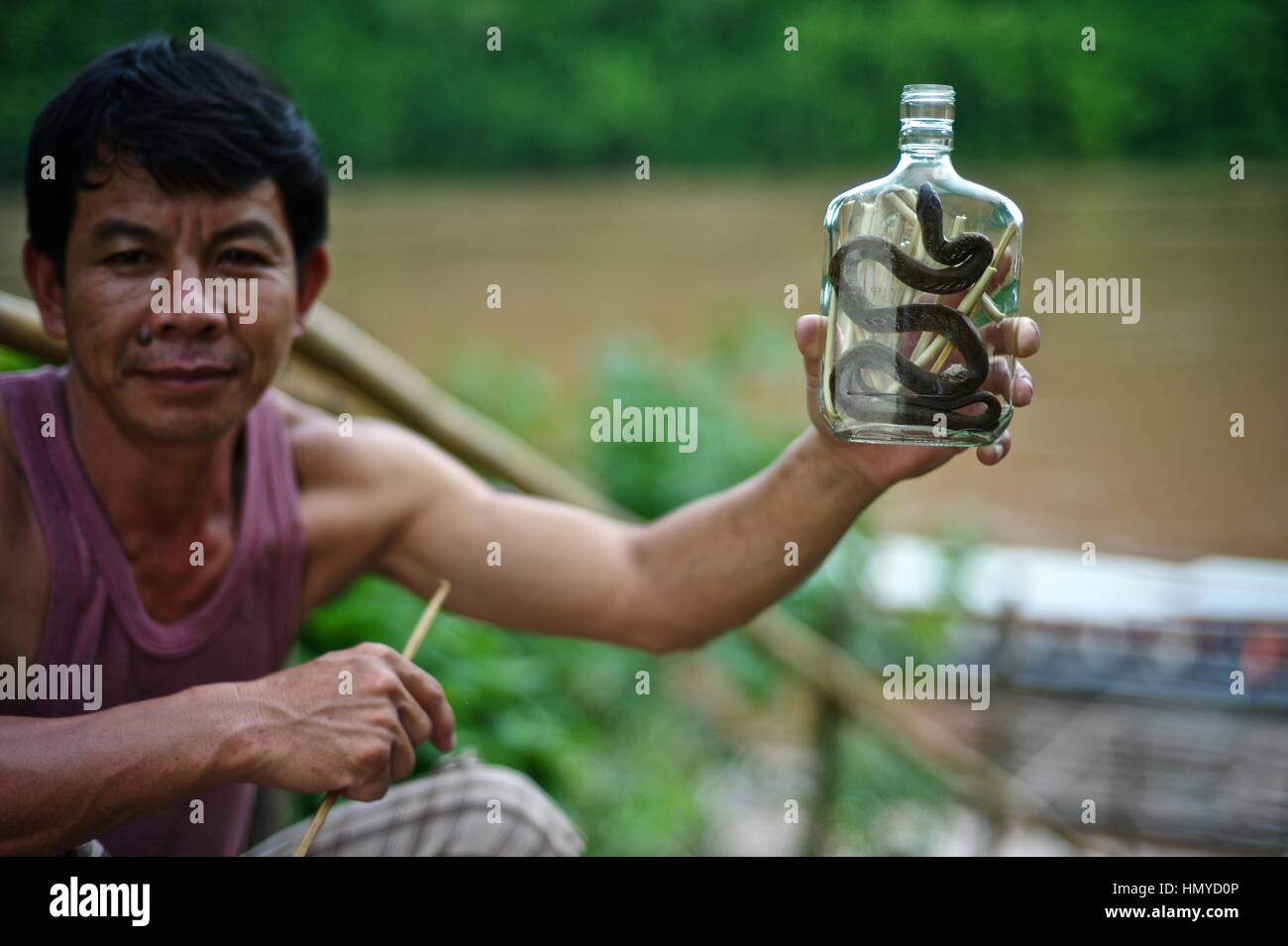 A man prepares Lao Lao whiskey in Whisky Village, known as Ban Xang Hai ...