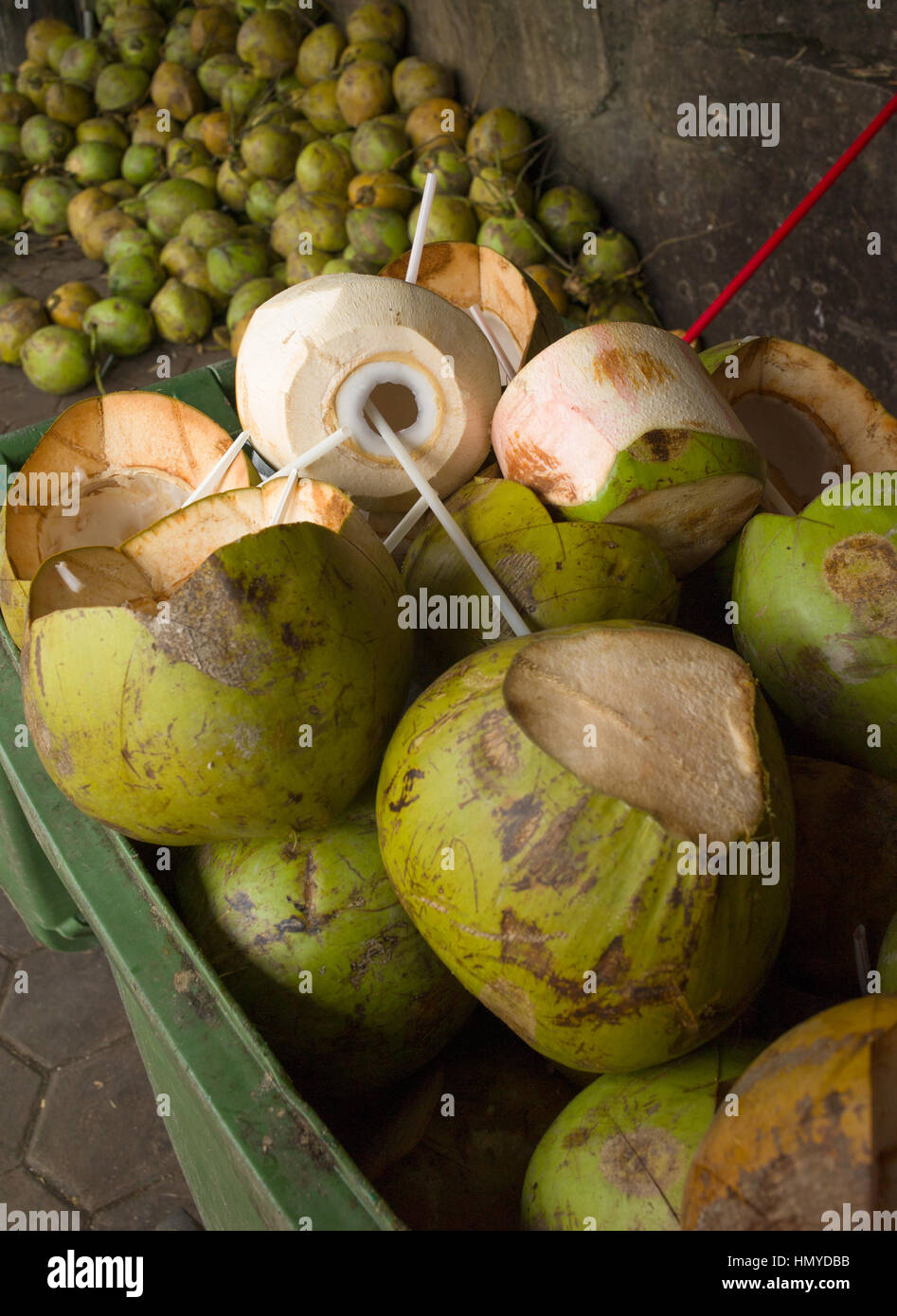 Pile of empty coconuts with drinking straws in waste bin after ...