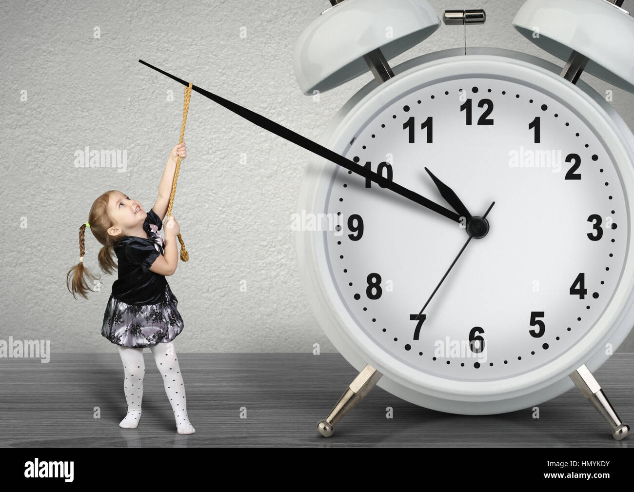 Little child girl pulling hand clock, time management concept Stock ...