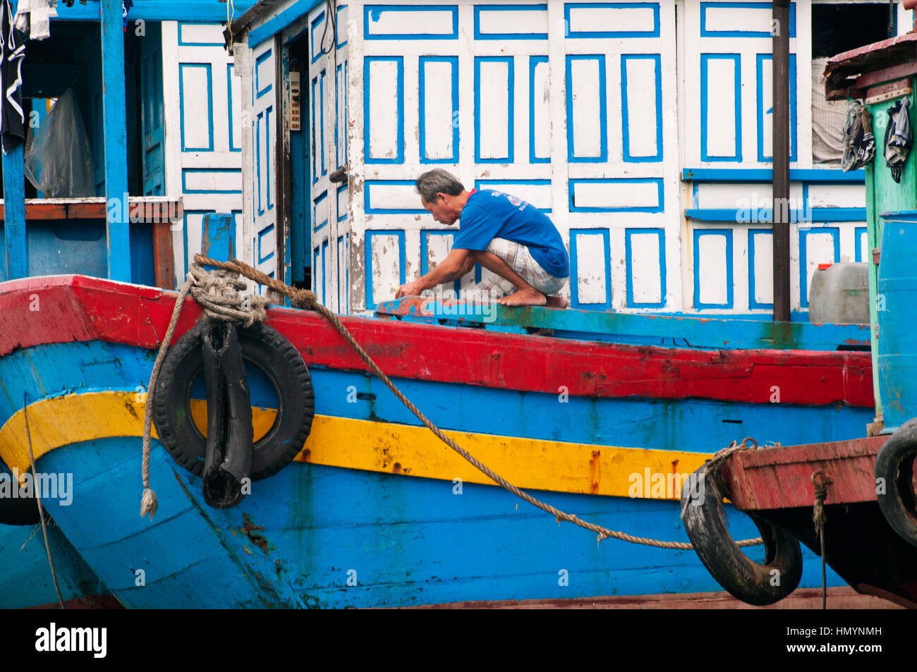Vietnam. Cat Ba Bay. Man working on his boat Stock Photo - Alamy