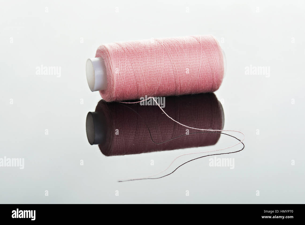 one pink thread lay horizontal on white background Stock Photo - Alamy
