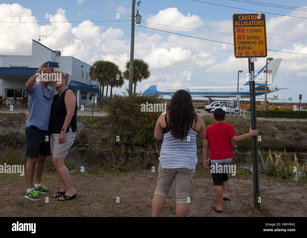 A sign cautions sightseers of alligators in a canal as they gather to ...
