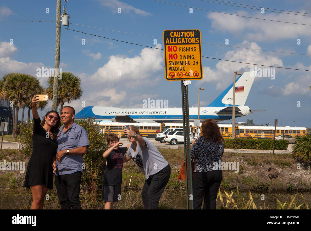 A sign cautions sightseers of alligators in a canal as they gather to ...